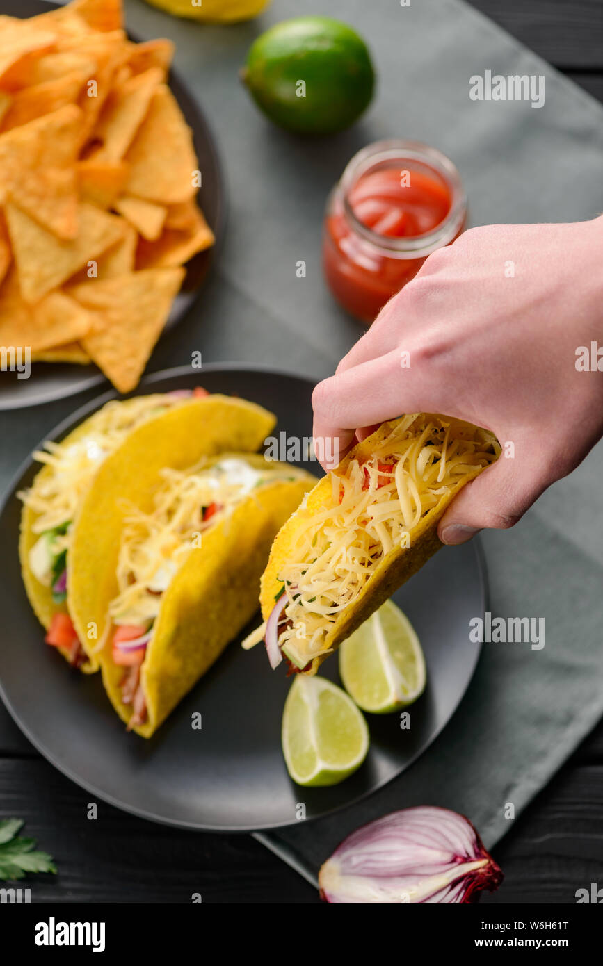 Hand taking a hard-shell taco Stock Photo - Alamy