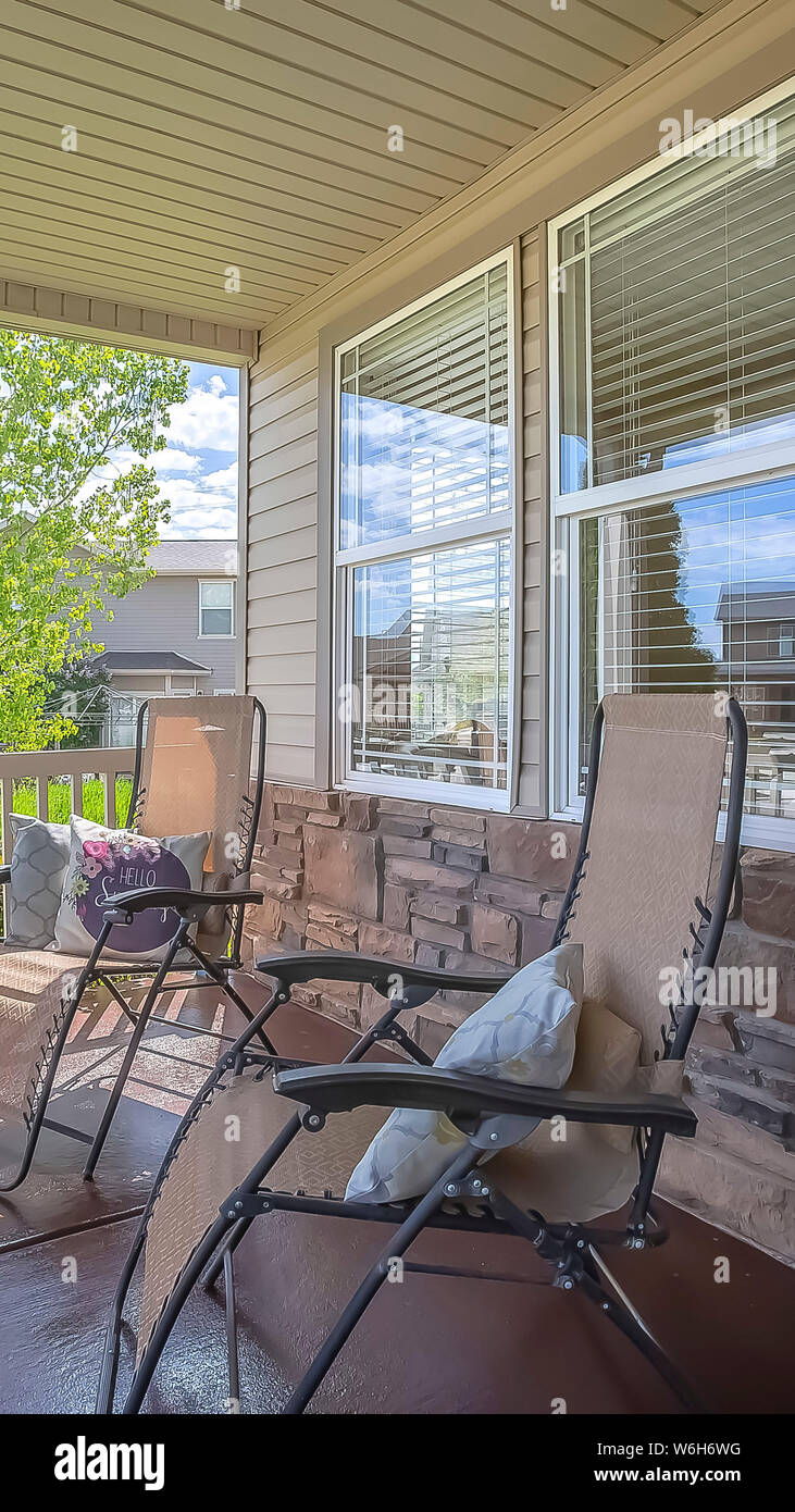 Vertical frame Relaxing seats on the porch of a home with view of the ...