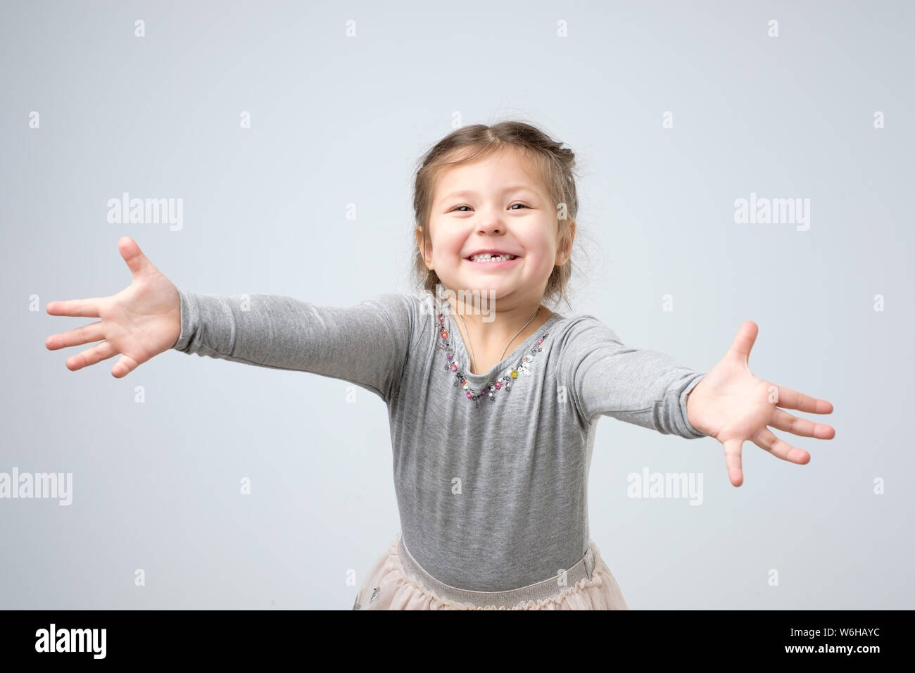 Female toddler stretching hands towards the camera, smiling from ...