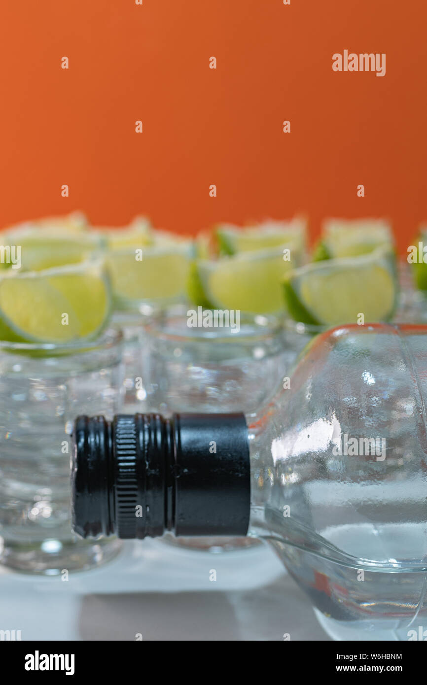 Detail of a bottle of tequila accompanied by shots of tequila with ...