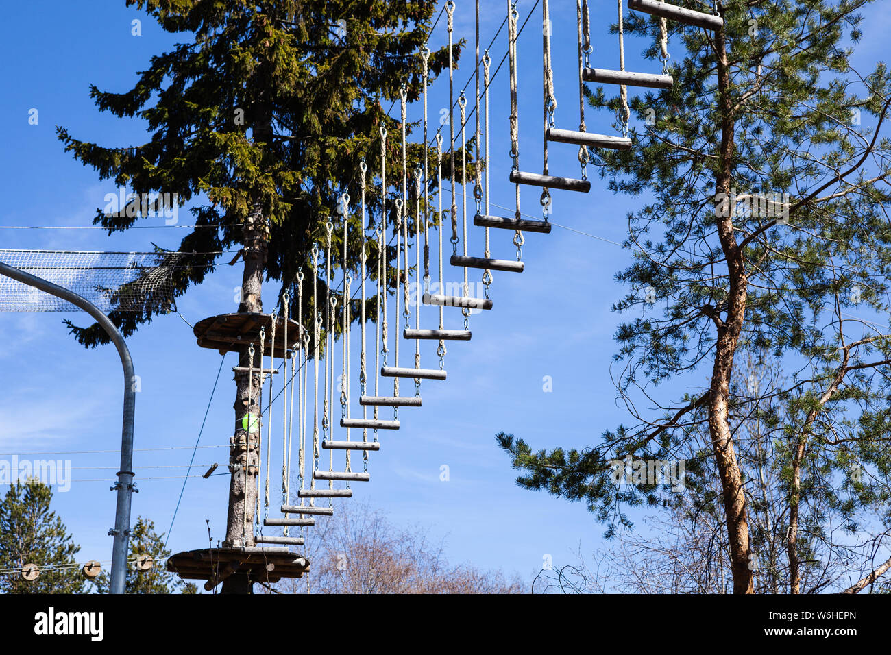 Rope adventure park in a summer forest scenic blue sky scenery ...