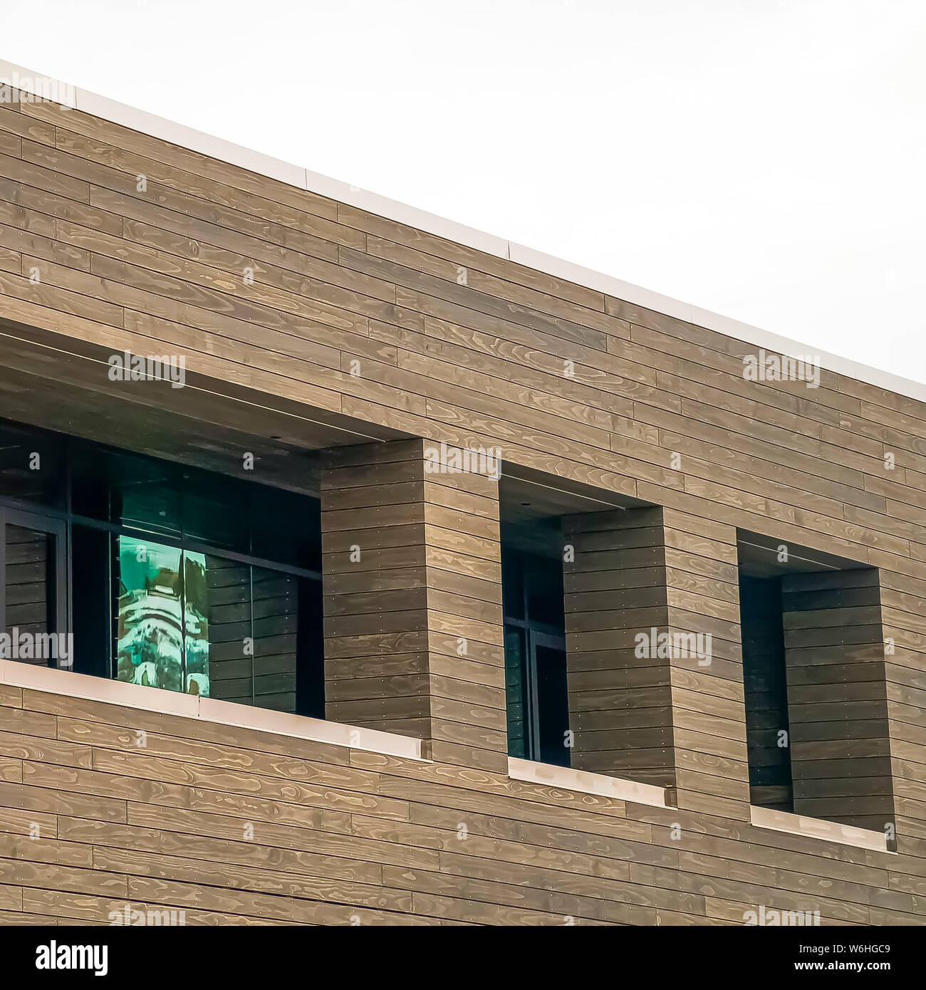 Square Close up view of a building with brown wood wall against bright ...