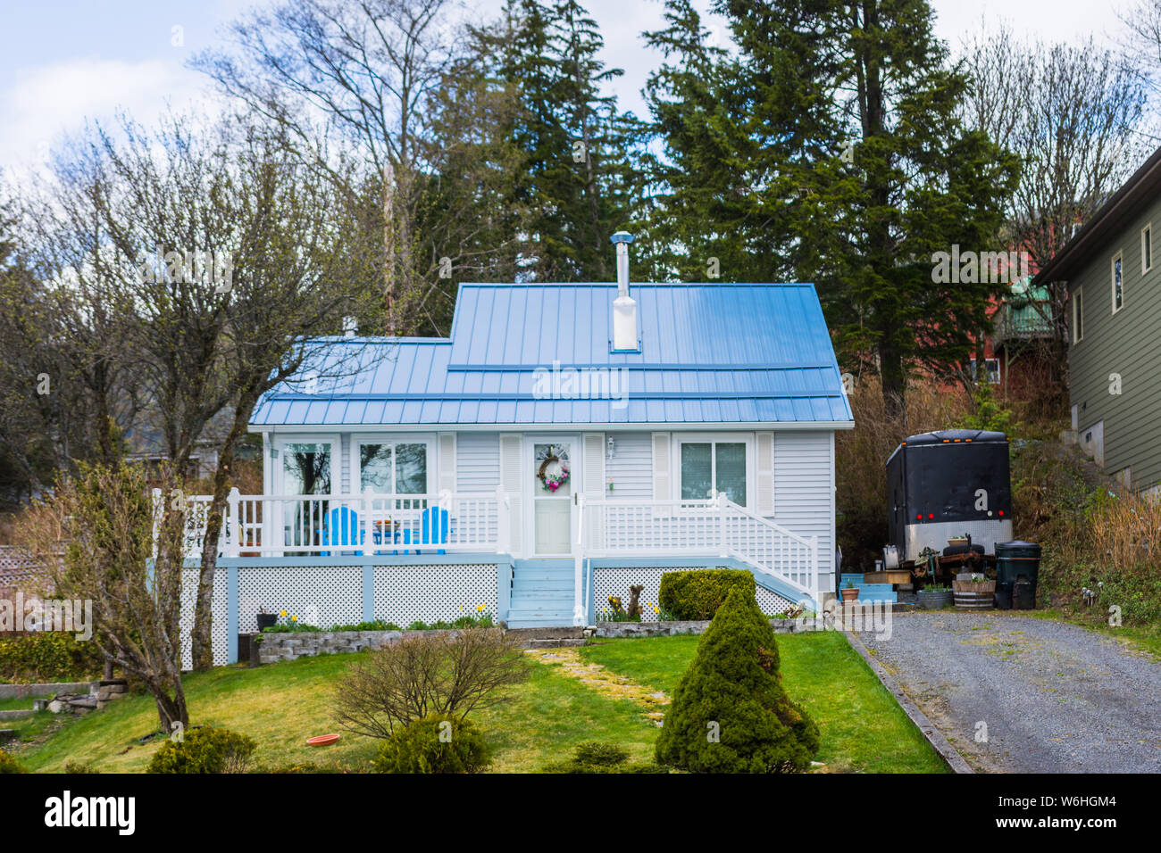 Simple, ordinary single family home with blue metal roof and front ...