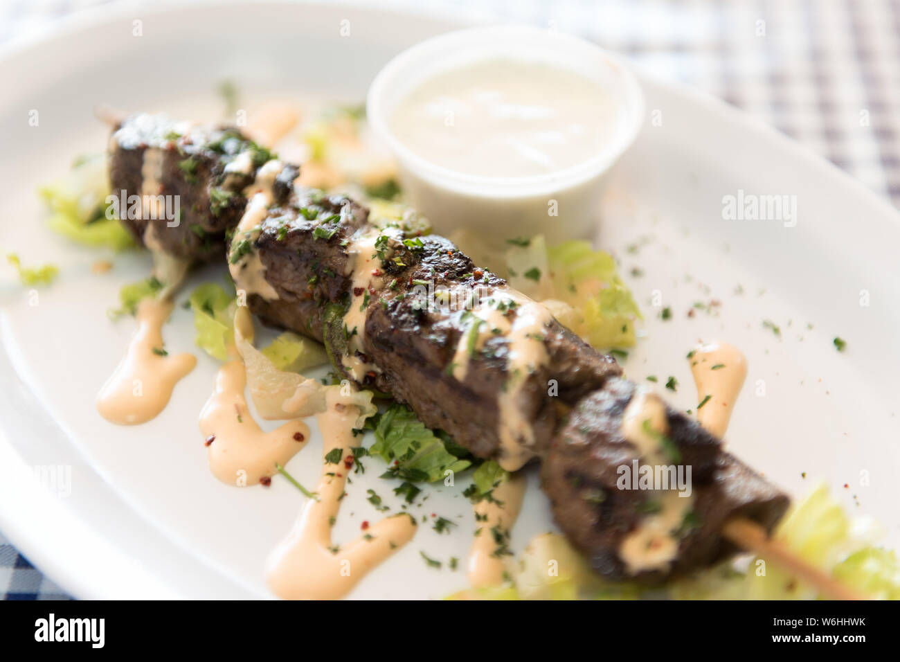 a beef skewer sits on a white plate Stock Photo - Alamy