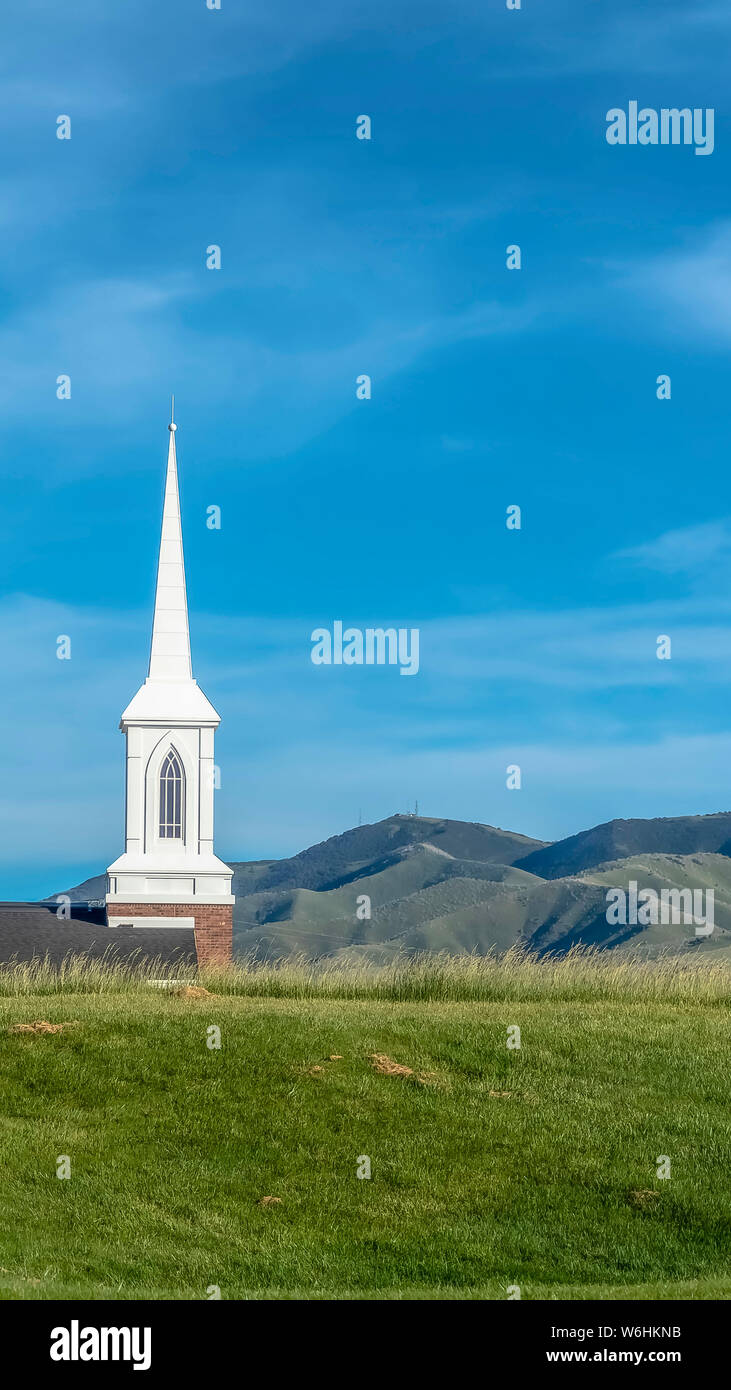 Vertical frame White steeple and rooftop of a church viewed from a ...