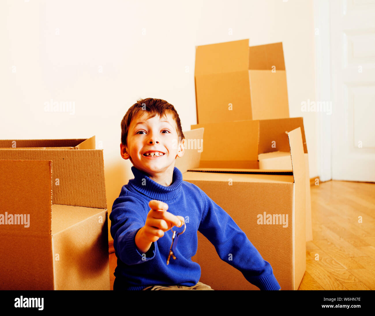 little cute boy in empty room with many boxes, remoove to new home ...