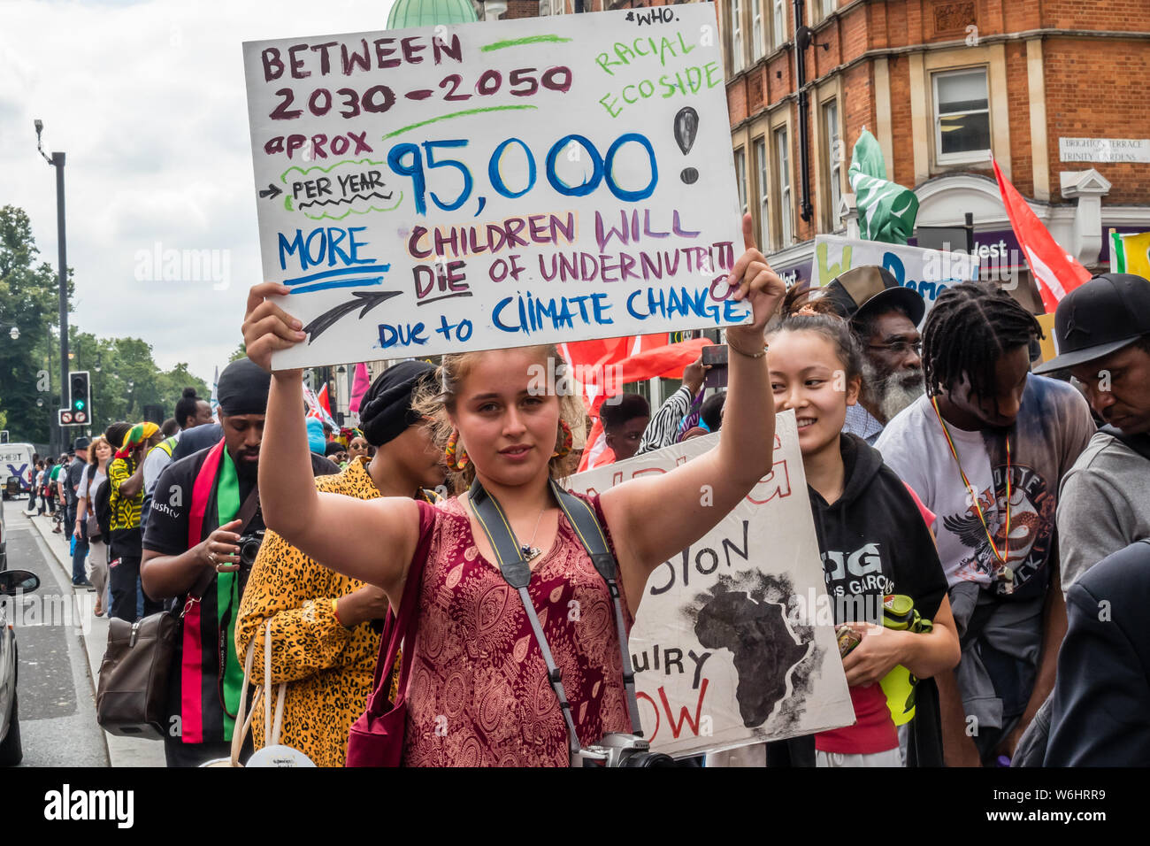 London, UK. 1st August 2019. A woman holds a poster about racial ...