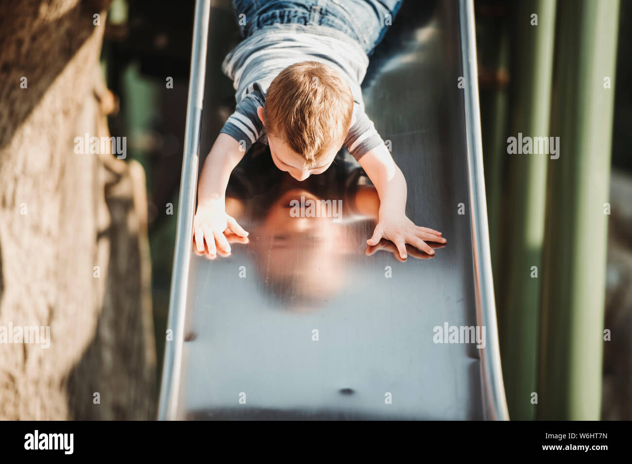 Happy boy going down slide hi-res stock photography and images - Alamy