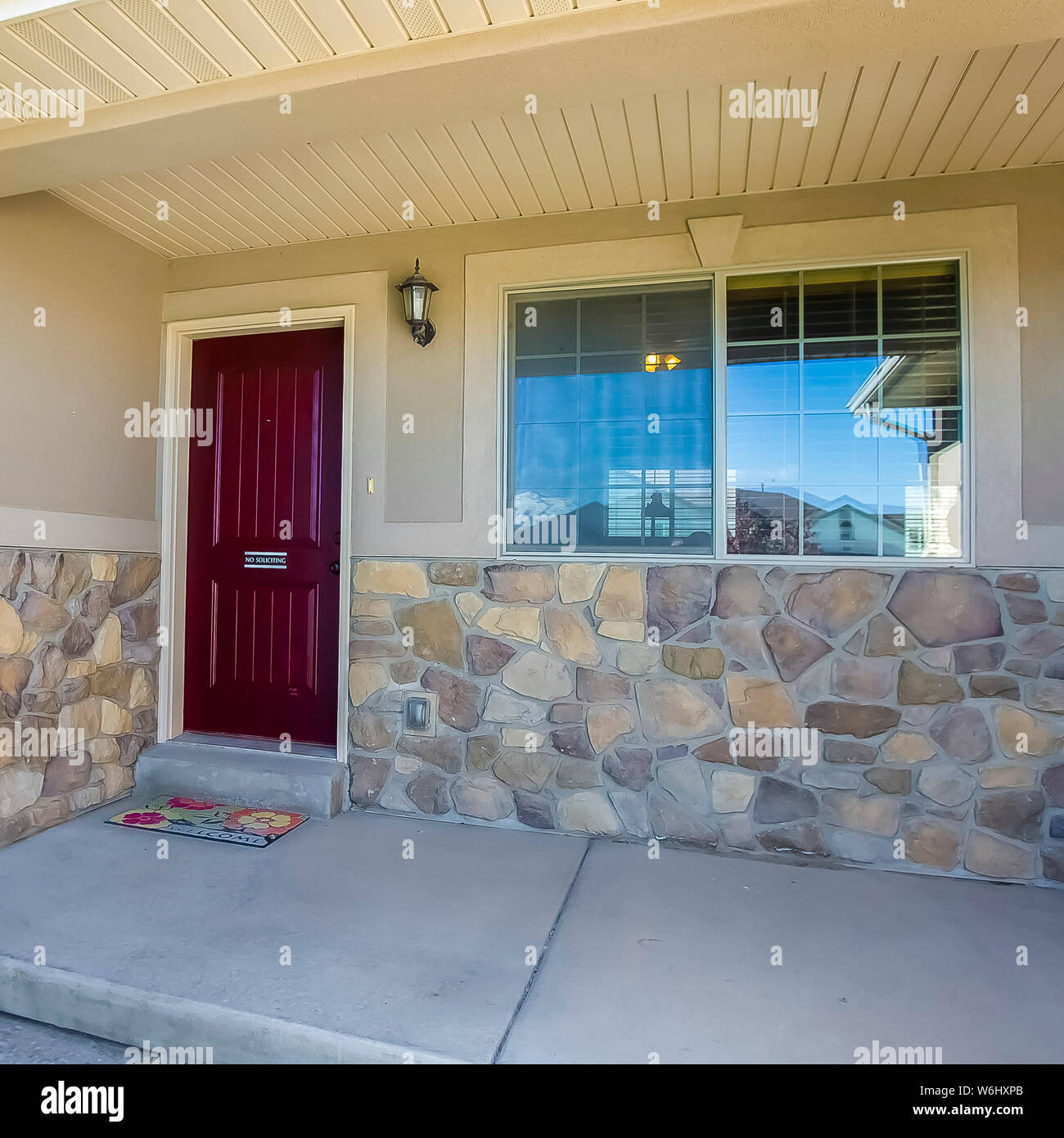 Square frame Home facade with maroon front door and combination of ...