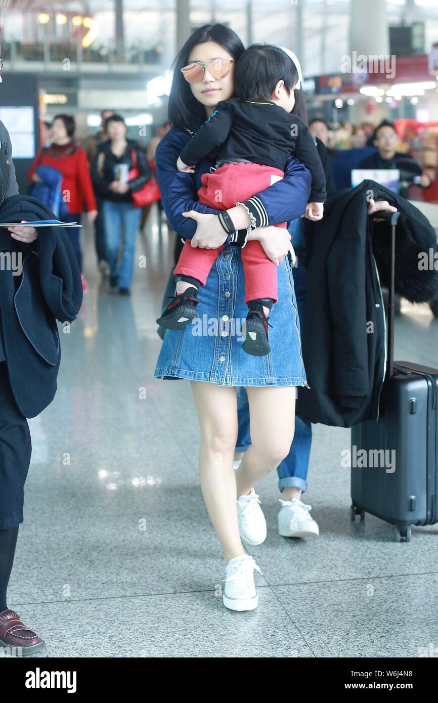 Taiwanese actress Michelle Chen carries her son at the Beijing Capital ...