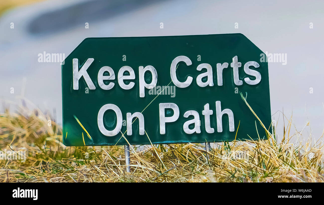 Panorama frame Close up of a sign that reads Keep Carts On Path beside ...