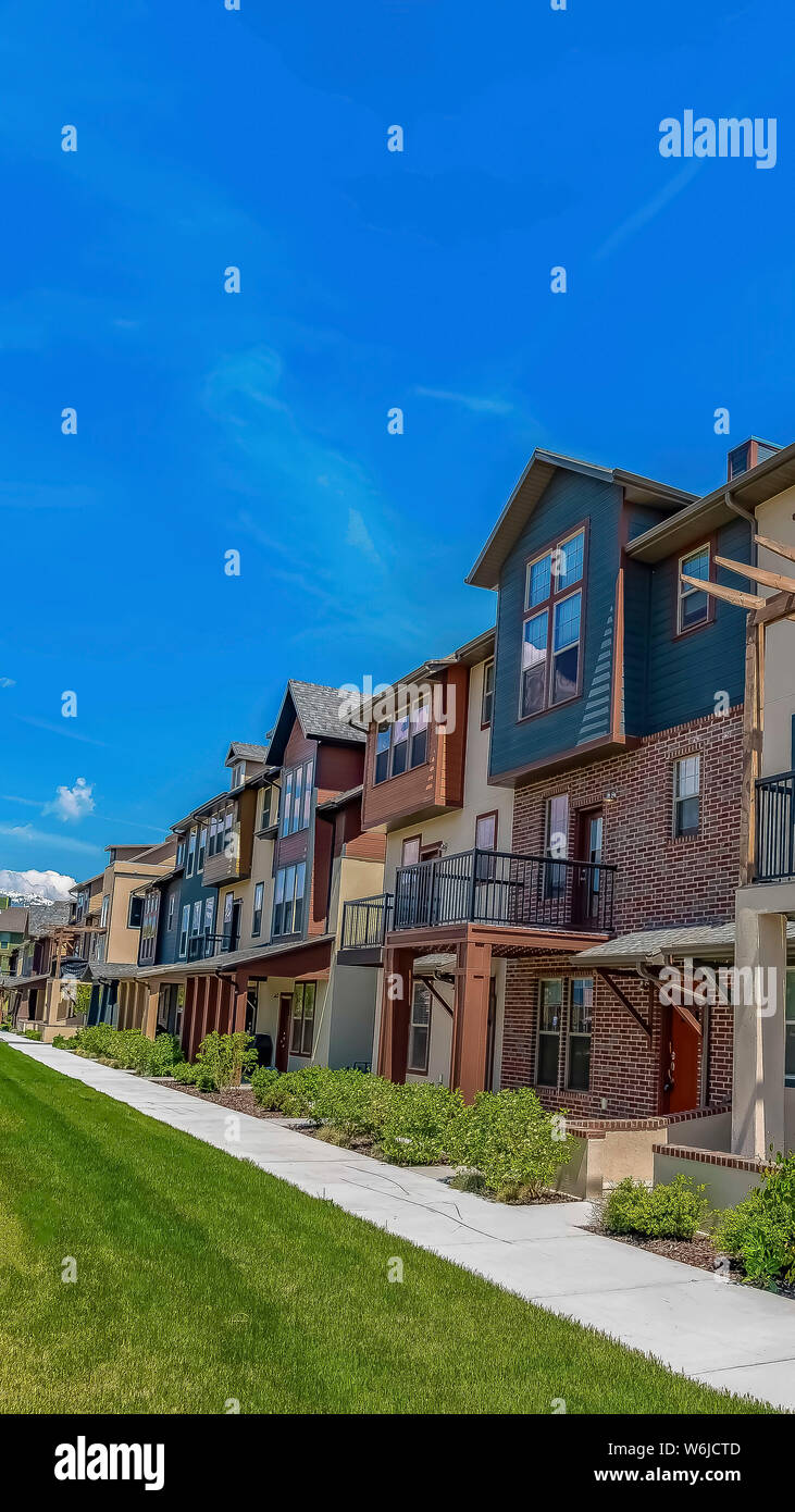 Vertical Row of homes with porches and small balconies under blue sky ...