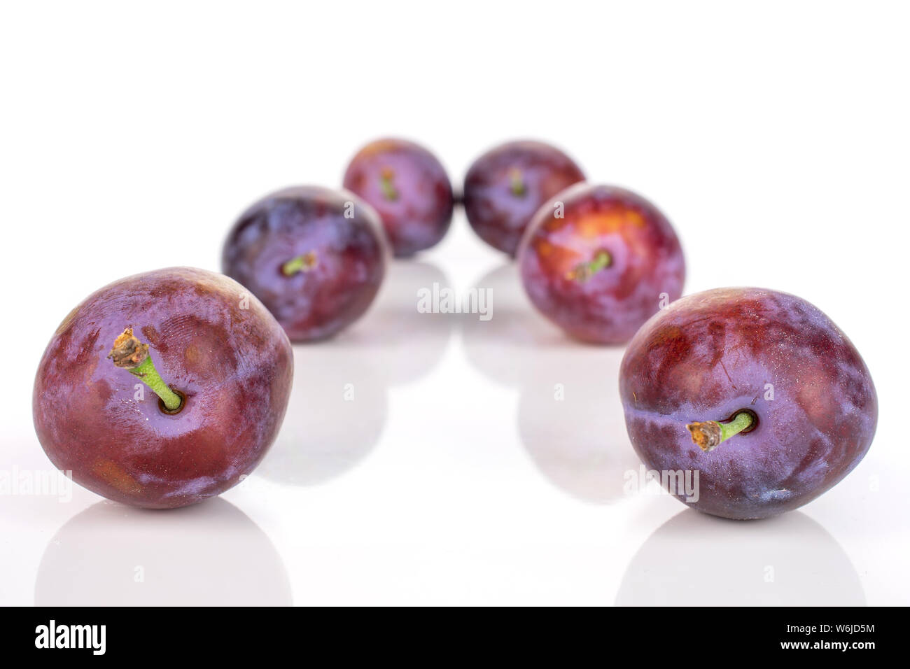 Group of six whole fresh blue plum arranged symmetrically isolated on ...