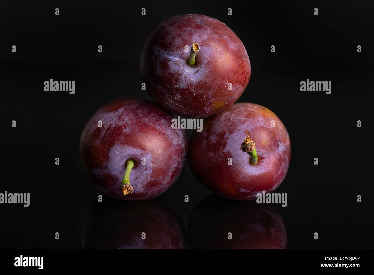 Group of three whole fresh blue plum arranged in a pyramid isolated on ...