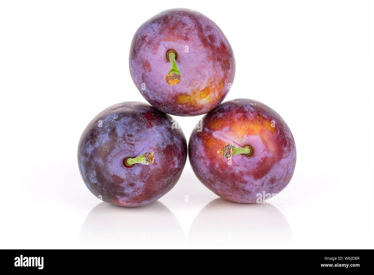 Group of three whole fresh blue plum arranged in a pyramid isolated on ...