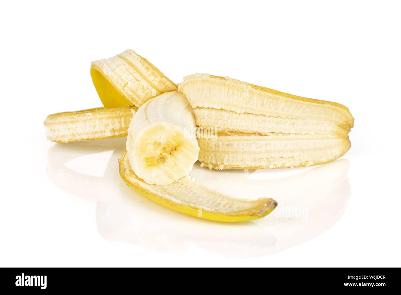 One half of ripe yellow banana halfway peeled and bitten off isolated ...