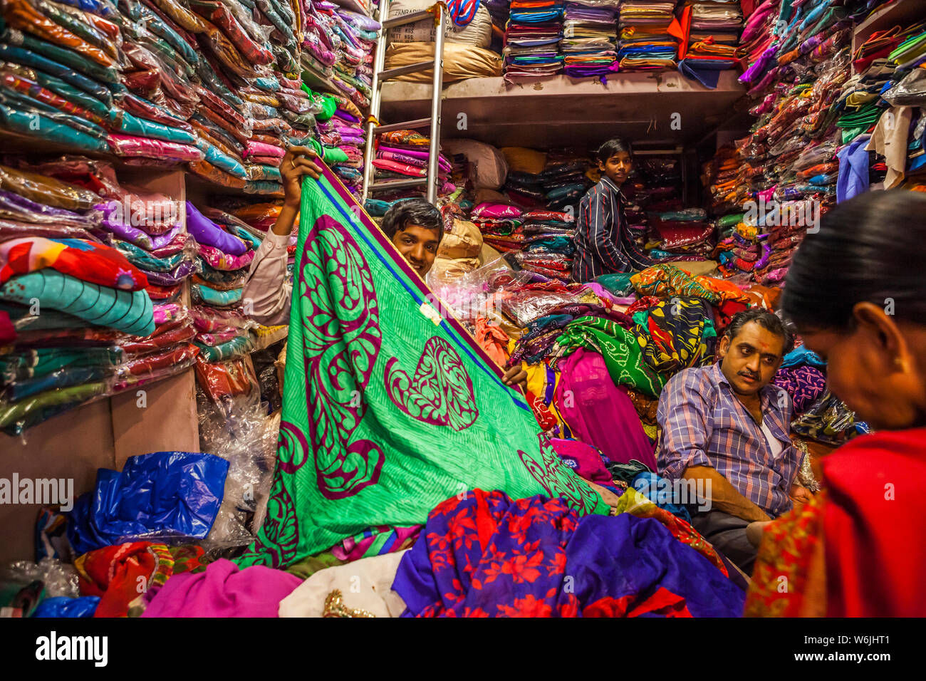 Piles of Saris in a sari shop manned by a father and his sons (just a ...