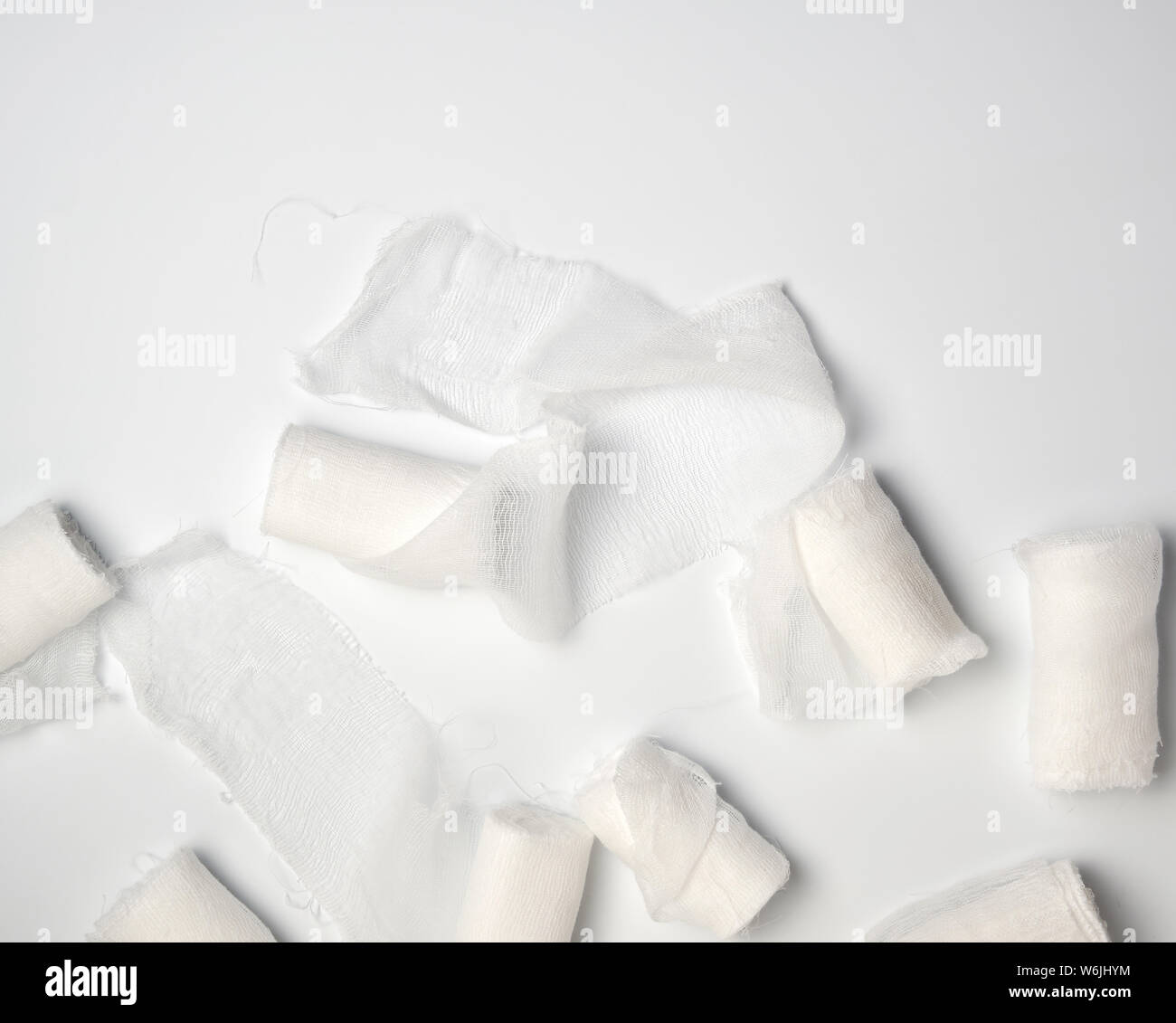 rolled up white sterile medical bandages on a white background, copy ...