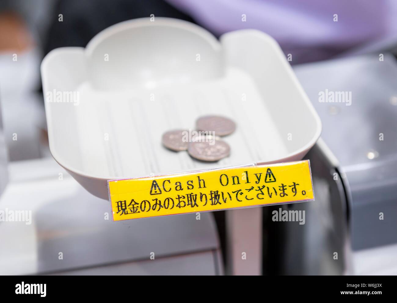 Money on cash register, sign in English and Japanese cash only, cash ...