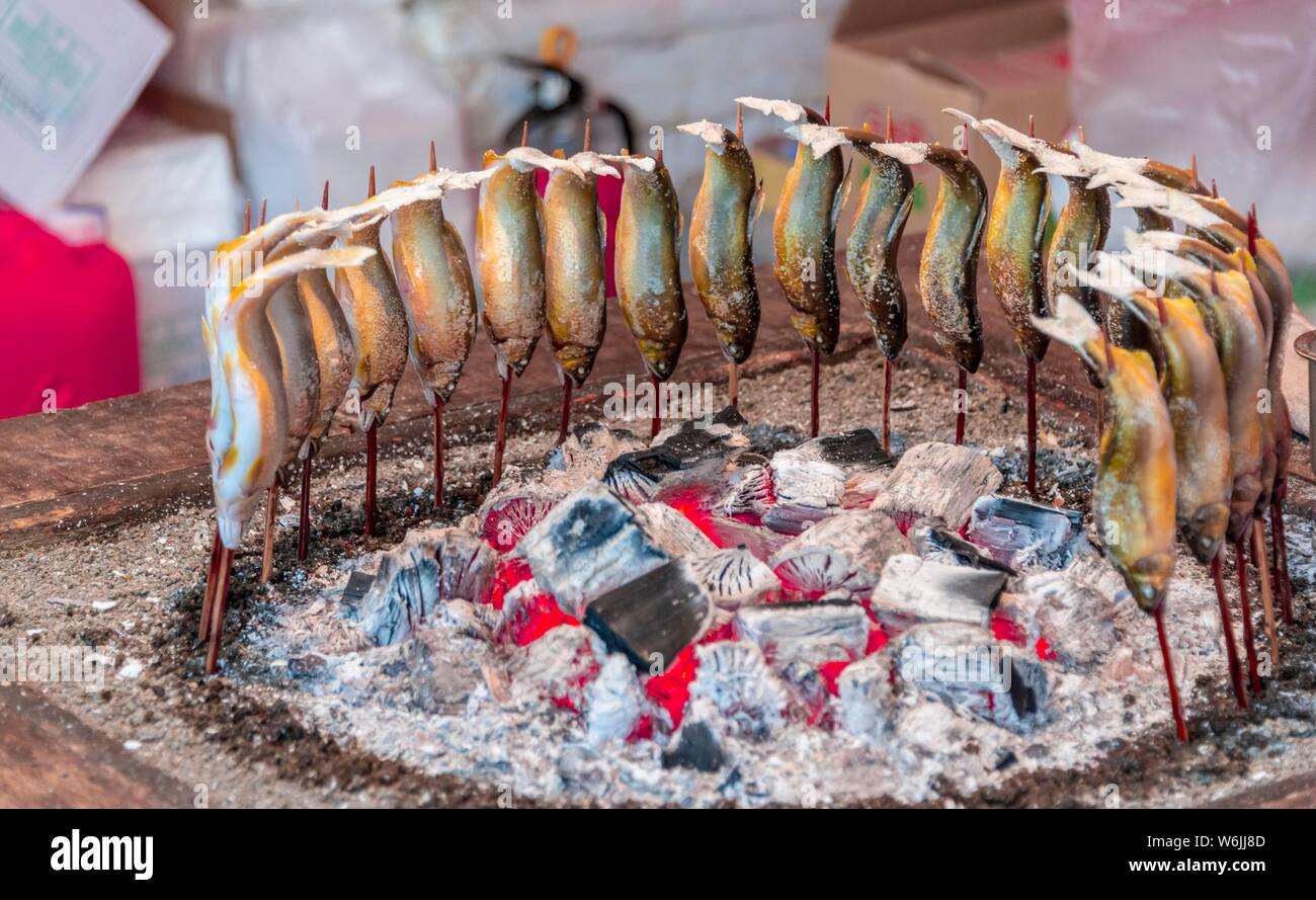 Grilled fish over fire at a food stall, Hanami Fest, Ueno Park, Tokyo ...