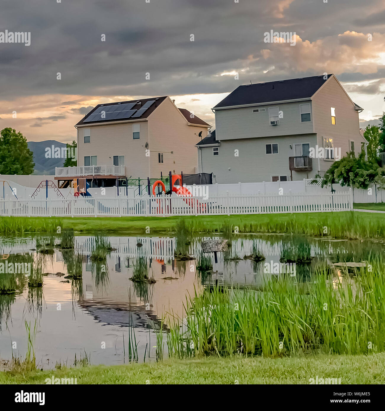 Square frame Shiny pond playground and multi storey homes surrounded by ...