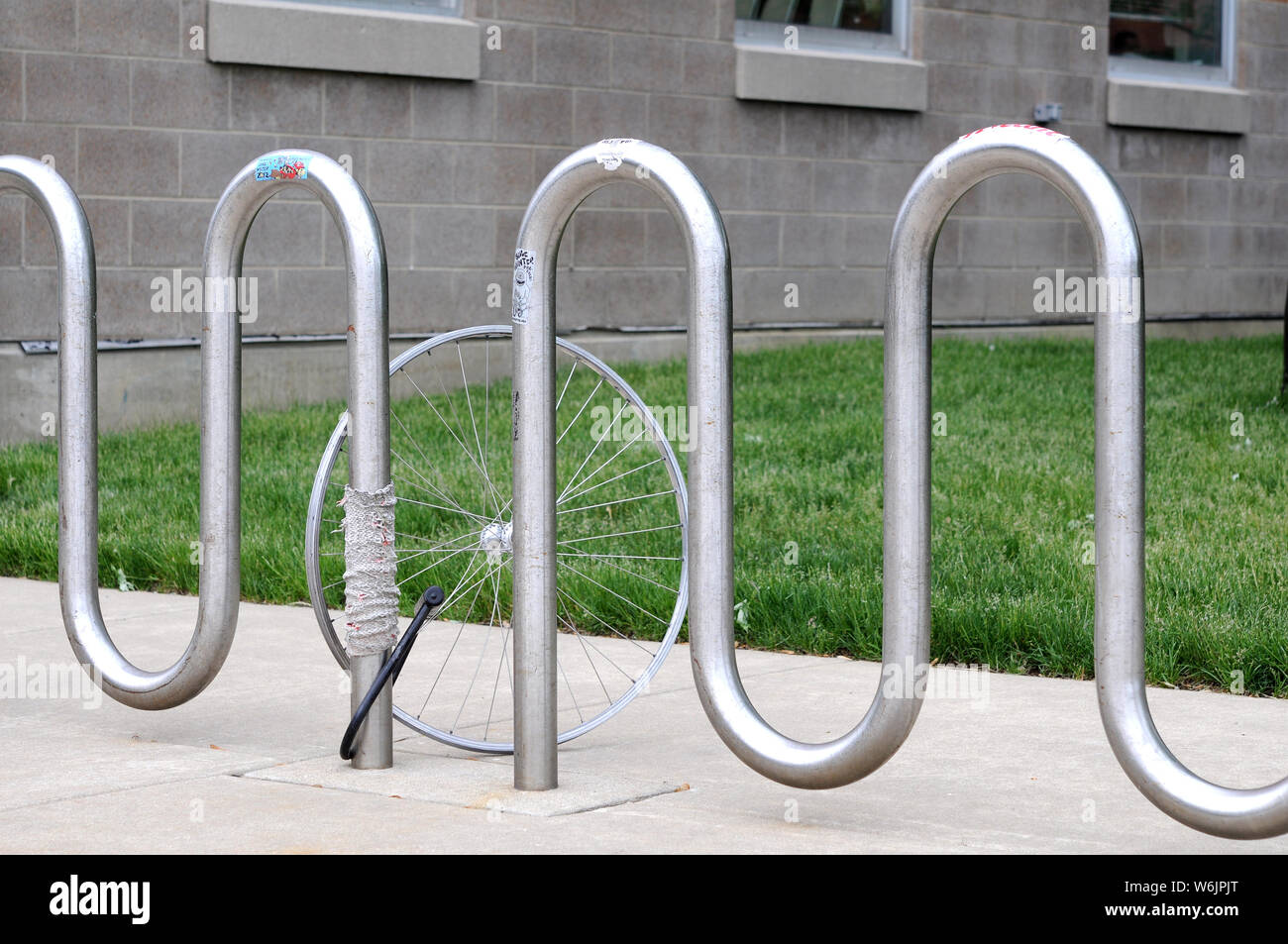 abandoned bike wheel locked with bike rack Stock Photo - Alamy