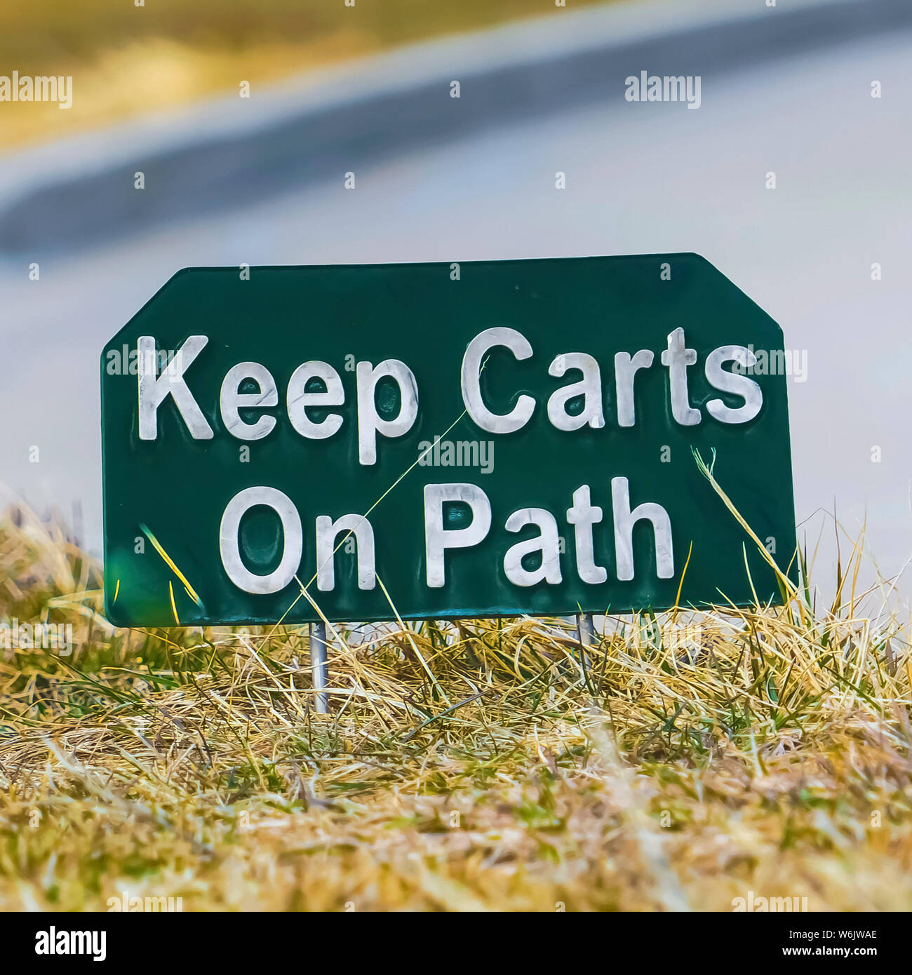 frame Close up of a sign that reads Keep Carts On Path beside a paved ...