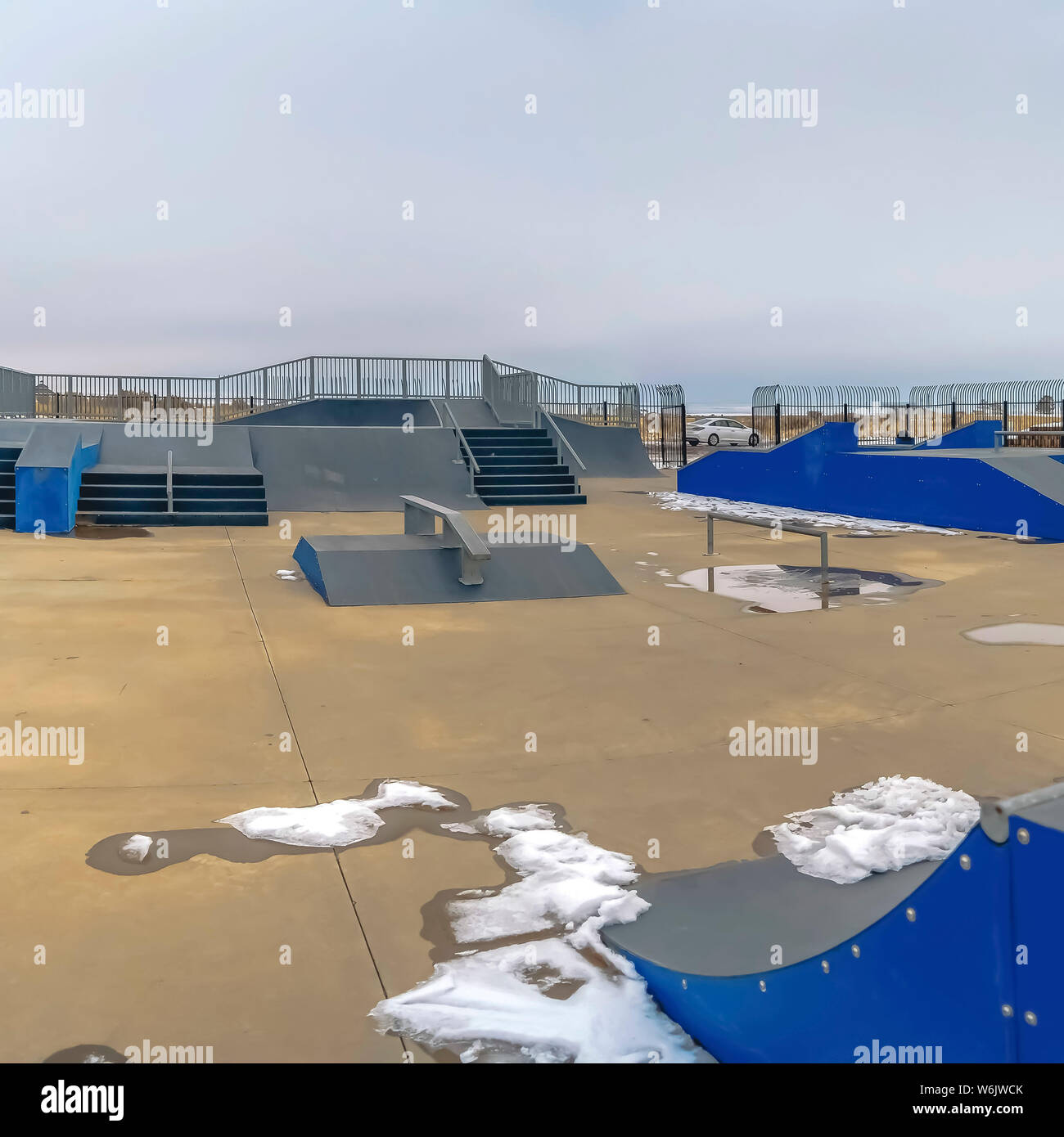 frame Skate park with various types of ramps under cloudy sky in winter ...