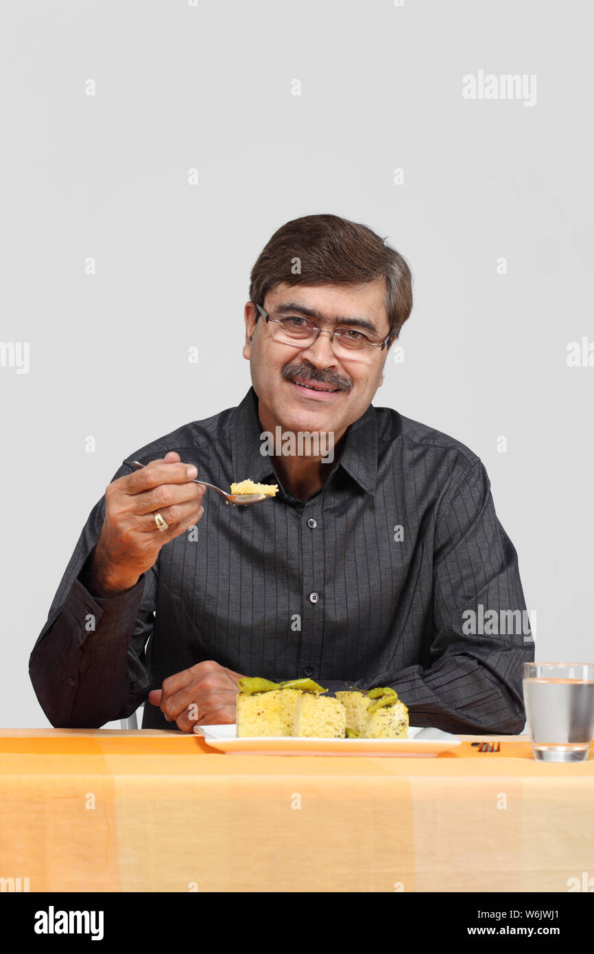 Man eating dhokla Stock Photo - Alamy