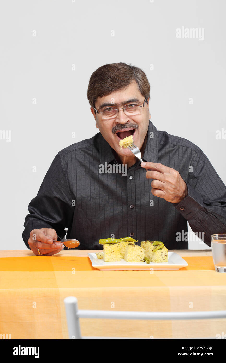 Man eating dhokla Stock Photo - Alamy