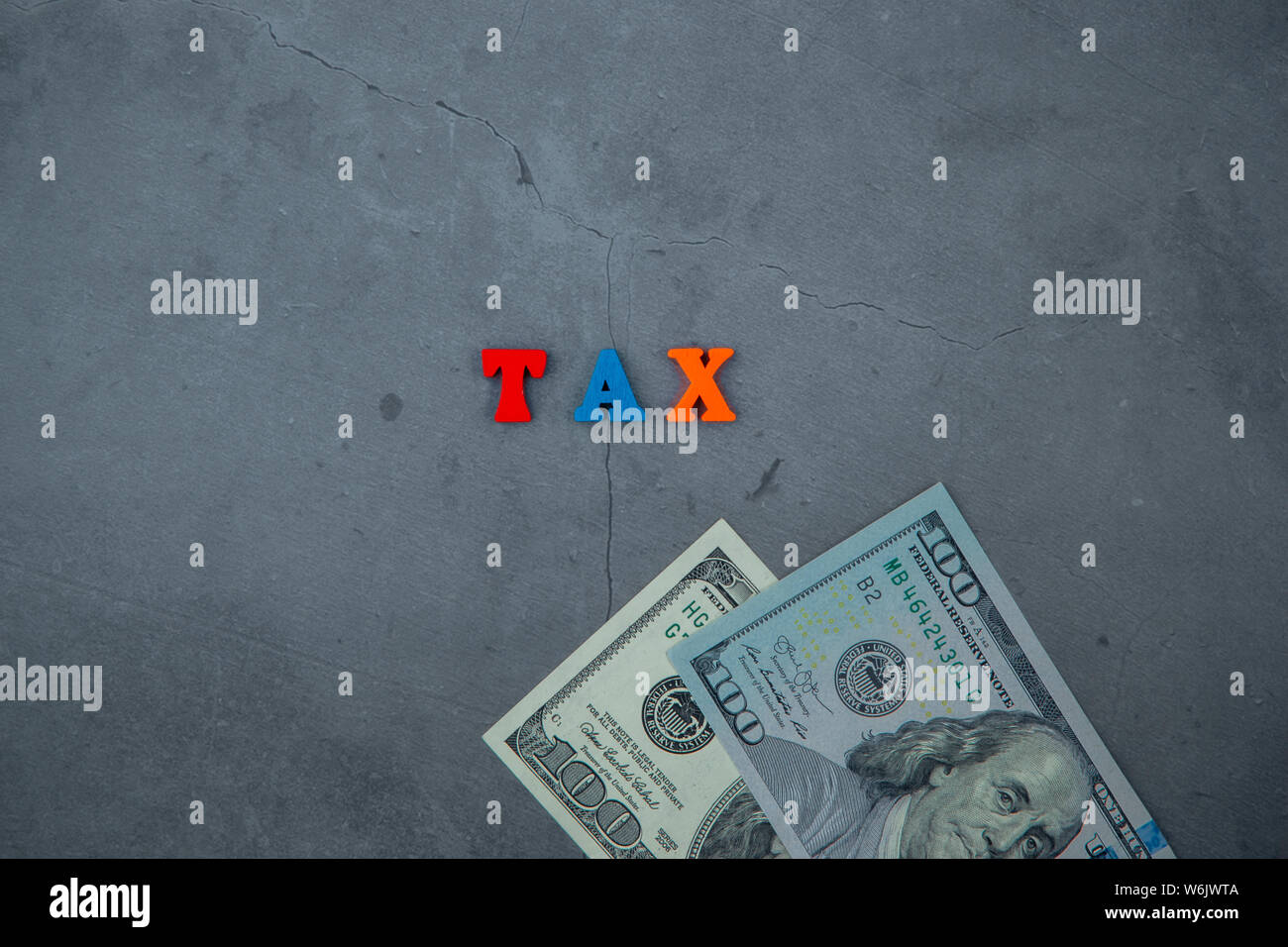 The multicolored tax word is made of wooden letters on a grey plastered ...