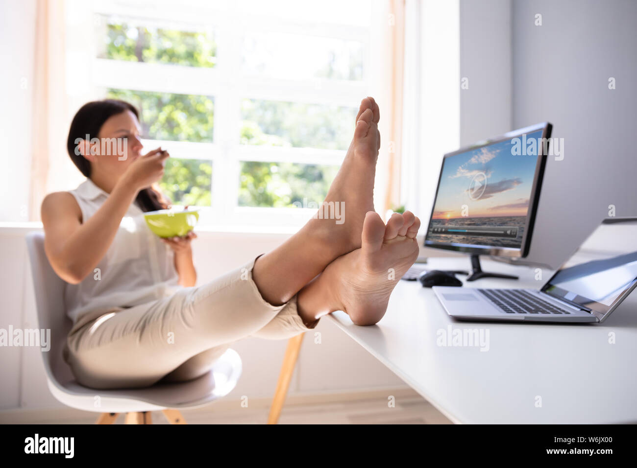 Side View Of Businesswoman Watching Video On Computer And Eating Food ...