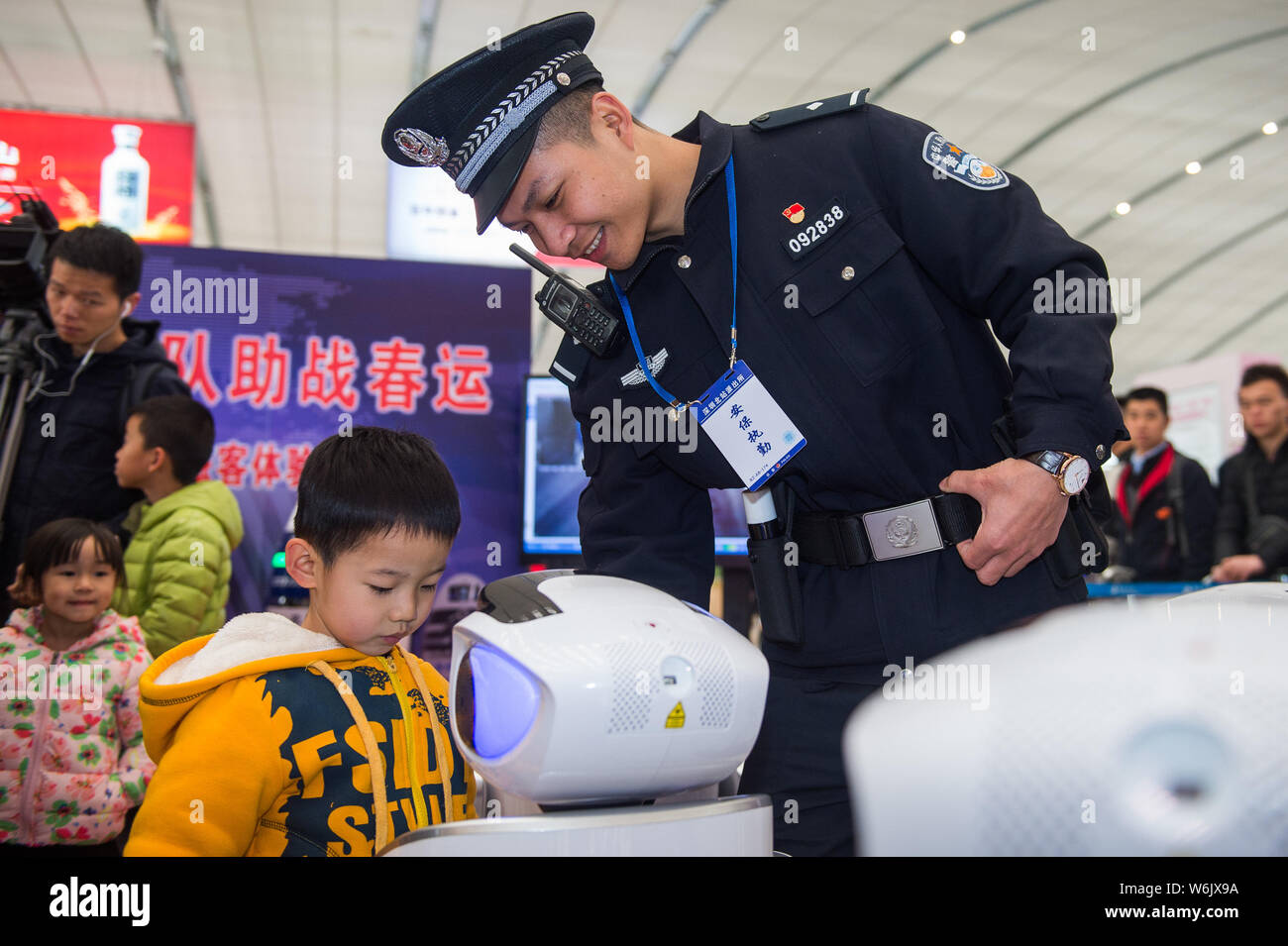 A police officer helps a child interact with one of the automated ...