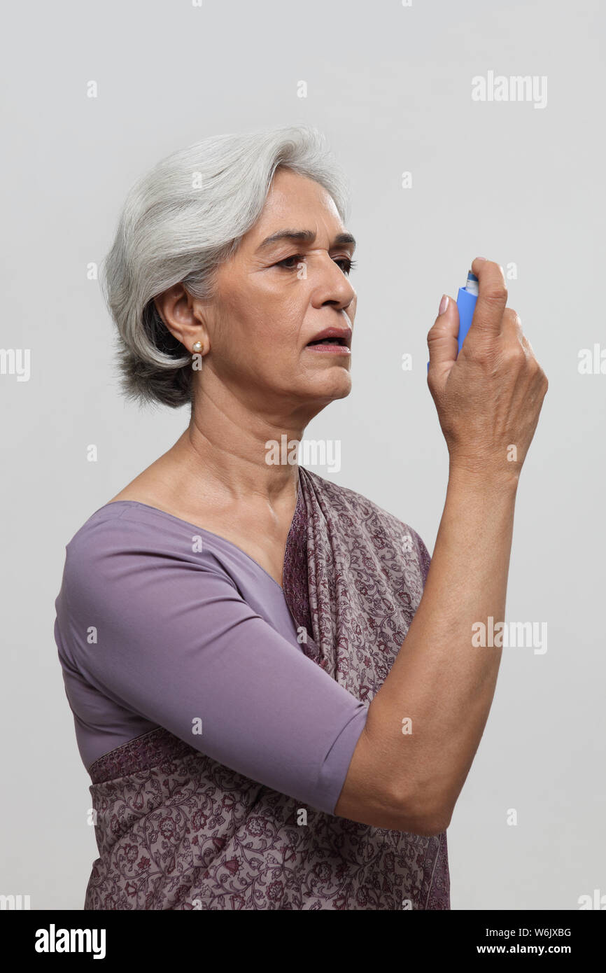 Old woman using asthma inhaler Stock Photo - Alamy