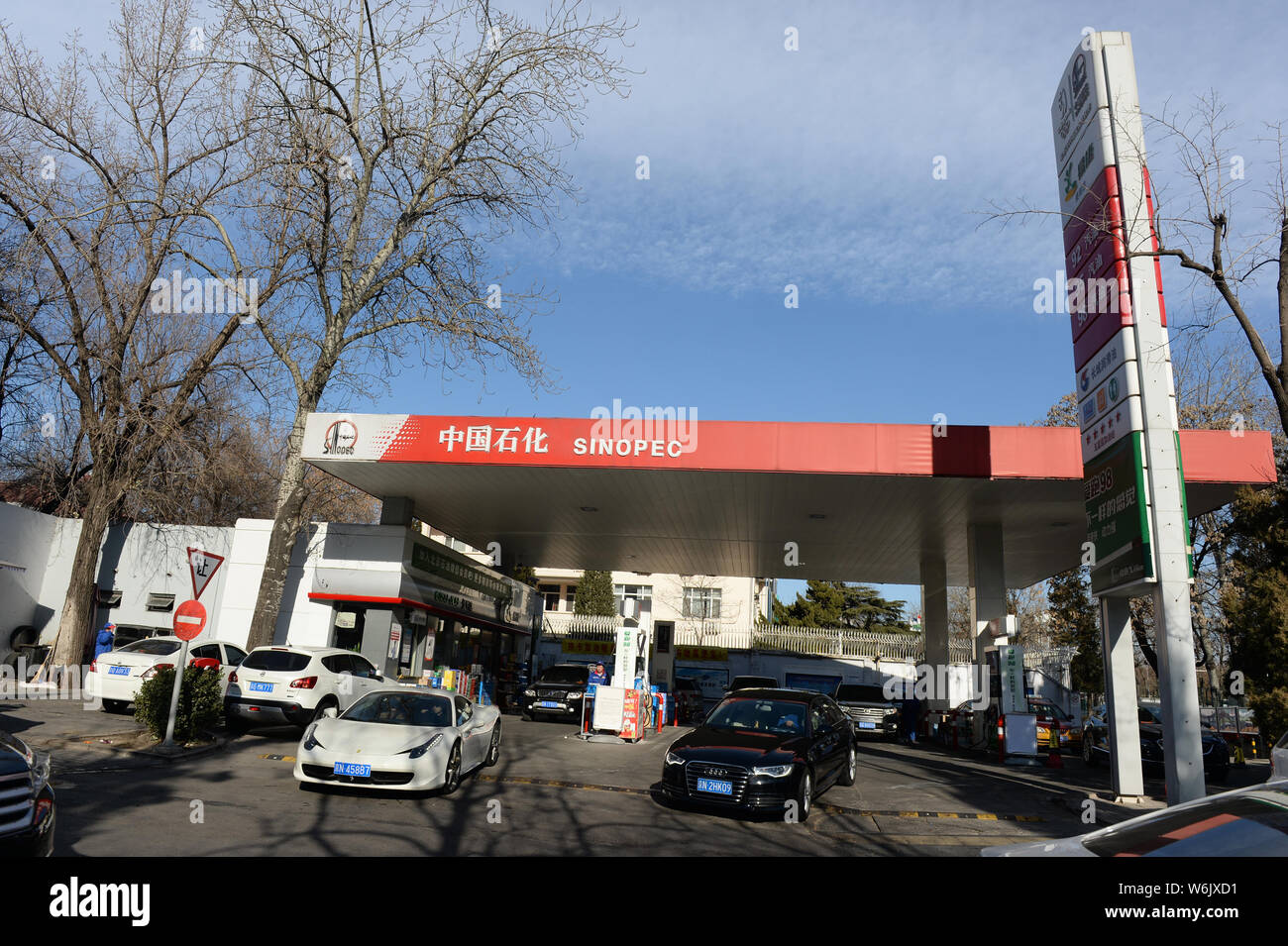 --FILE--Chinese drivers line up their cars to be refuelled at a gas ...