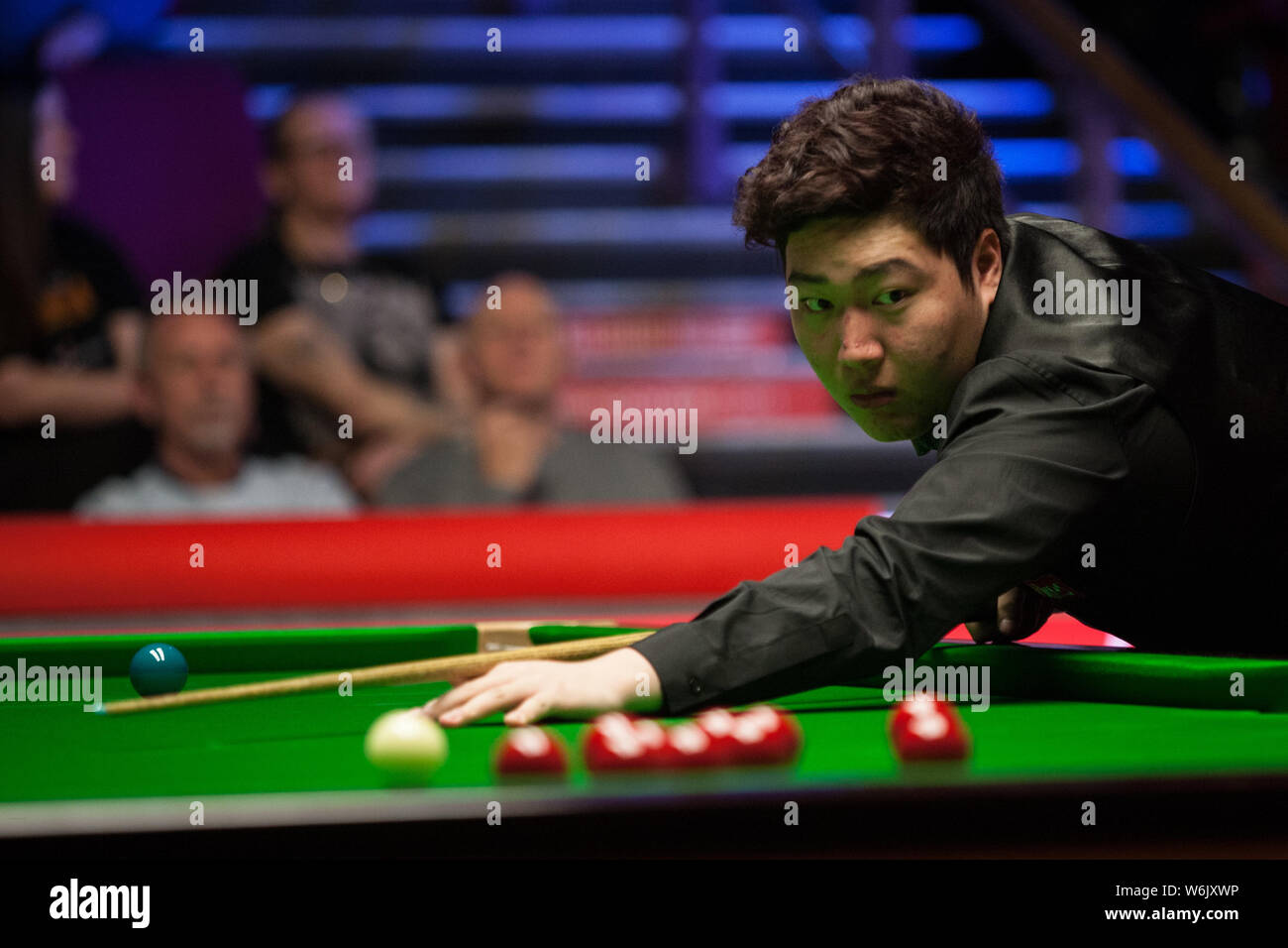 Yan Bingtao of China plays a shot to Martin Gould of England in their ...