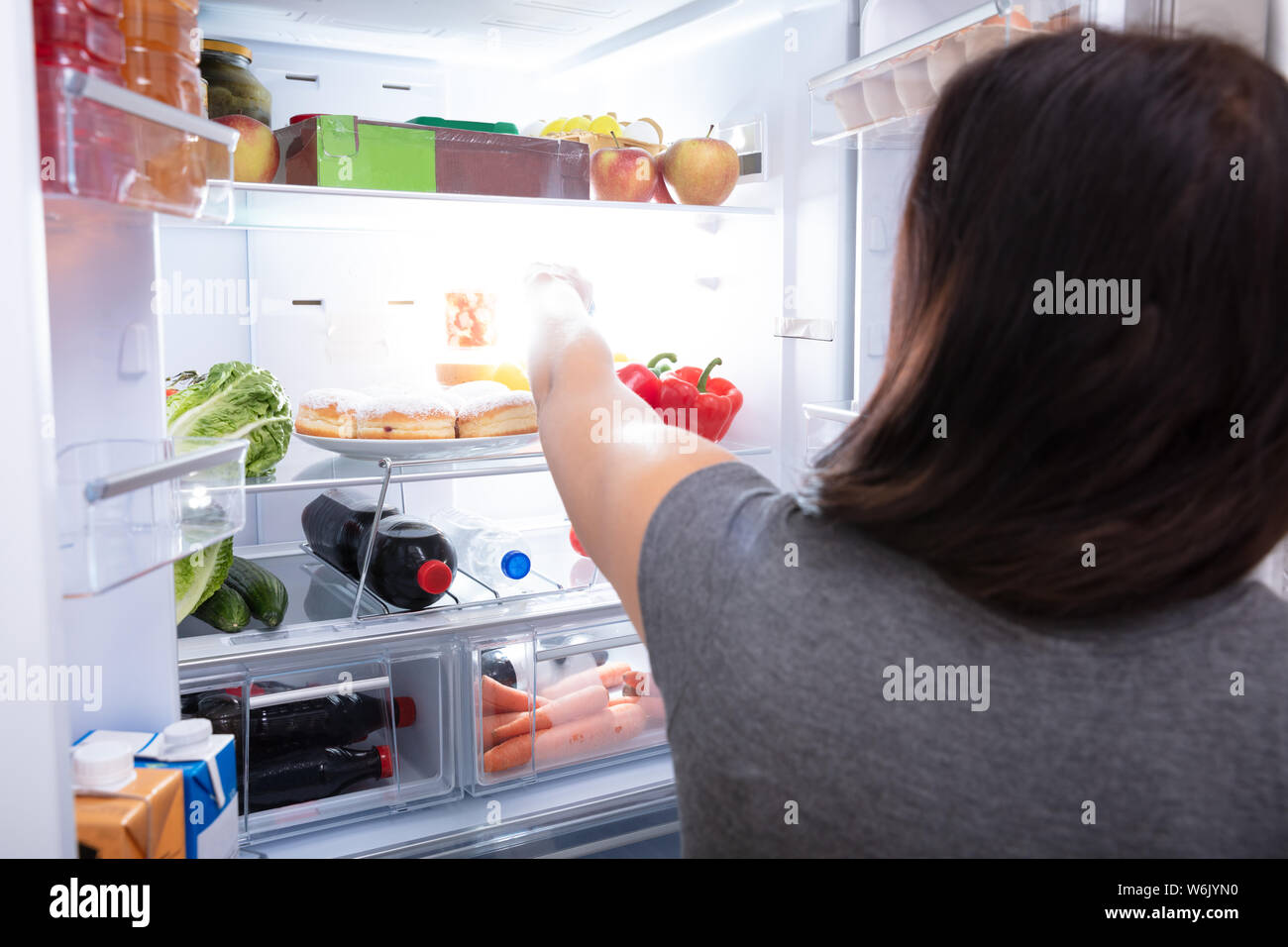 Rear View Of A Young Woman Taking Food From Refrigerator Stock Photo ...