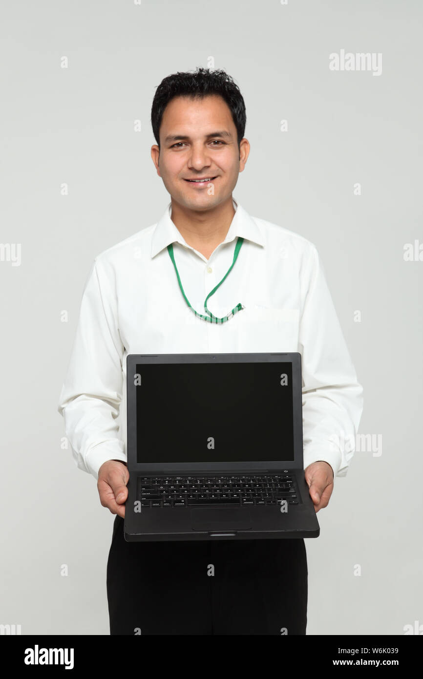 Salesman showing a laptop and smiling Stock Photo - Alamy