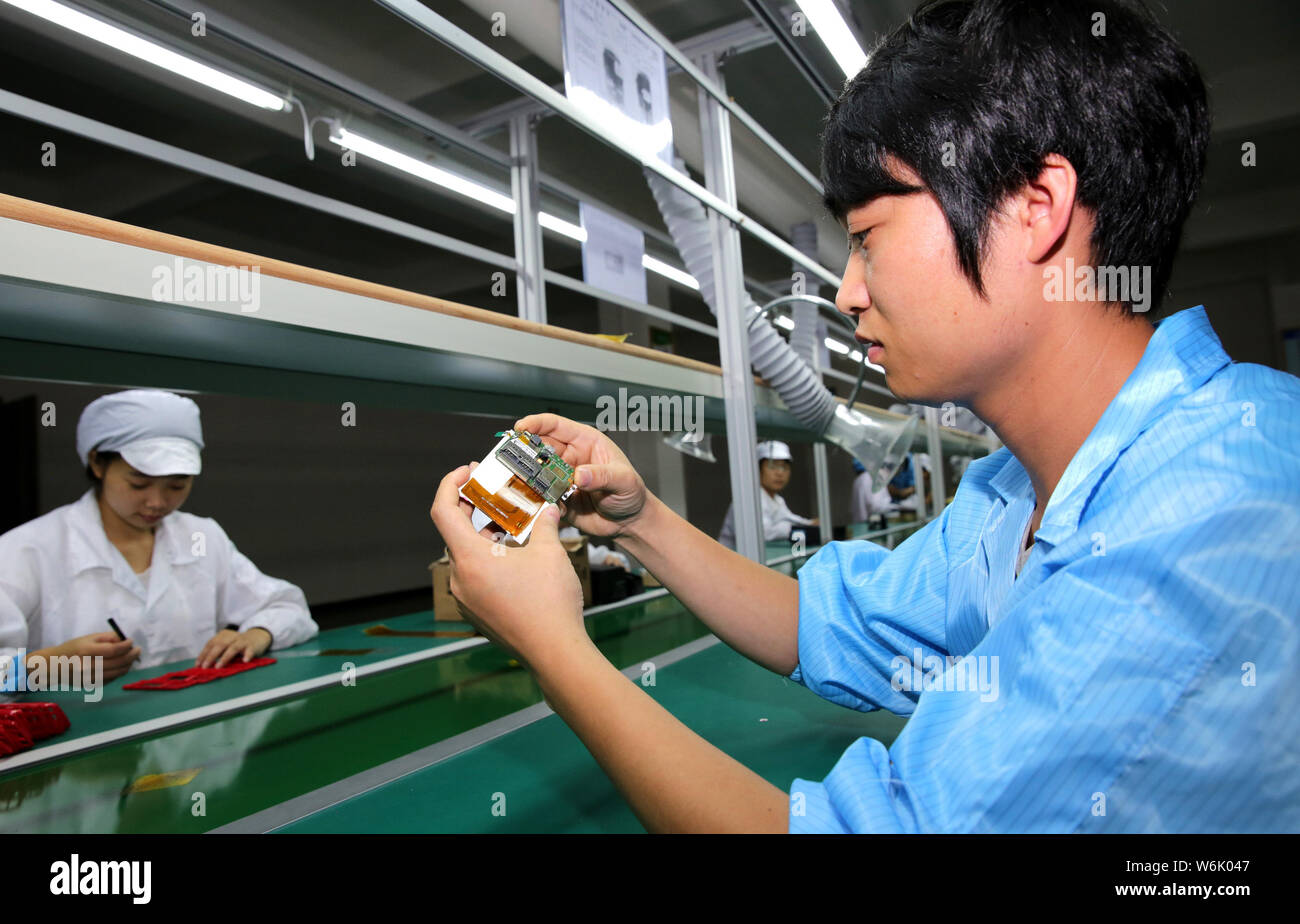 --FILE--Chinese workers assemble mobile phones at a factory in Huaying ...