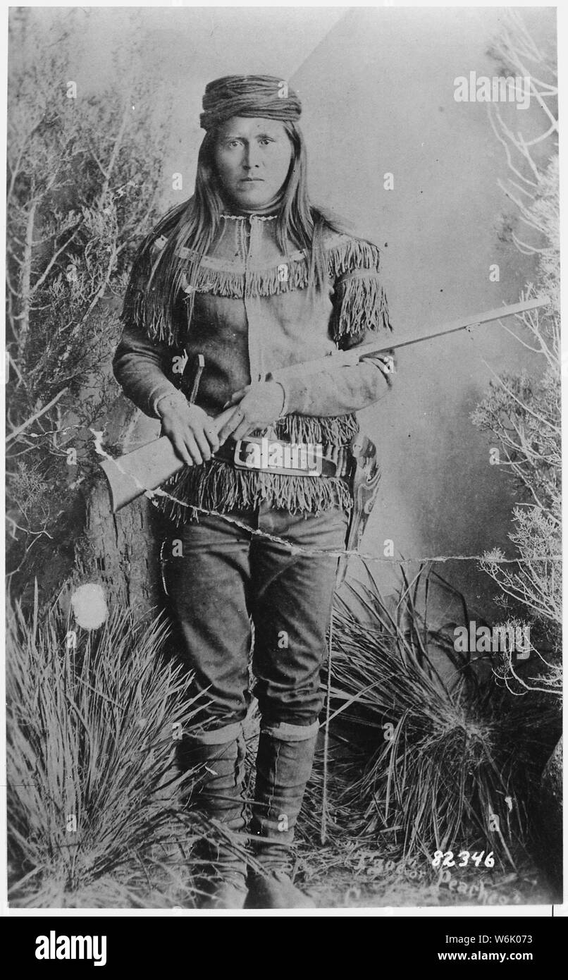 Peaches (Tsoe), a White Mountain Apache scout; full-length, holding ...
