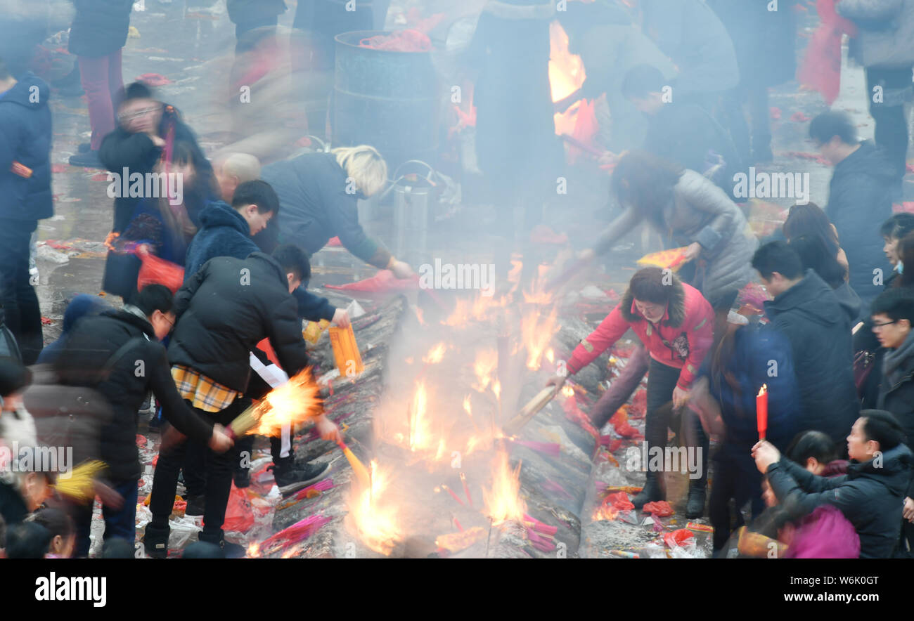 Chinese worshippers burn incense sticks to pray for wealth and ...