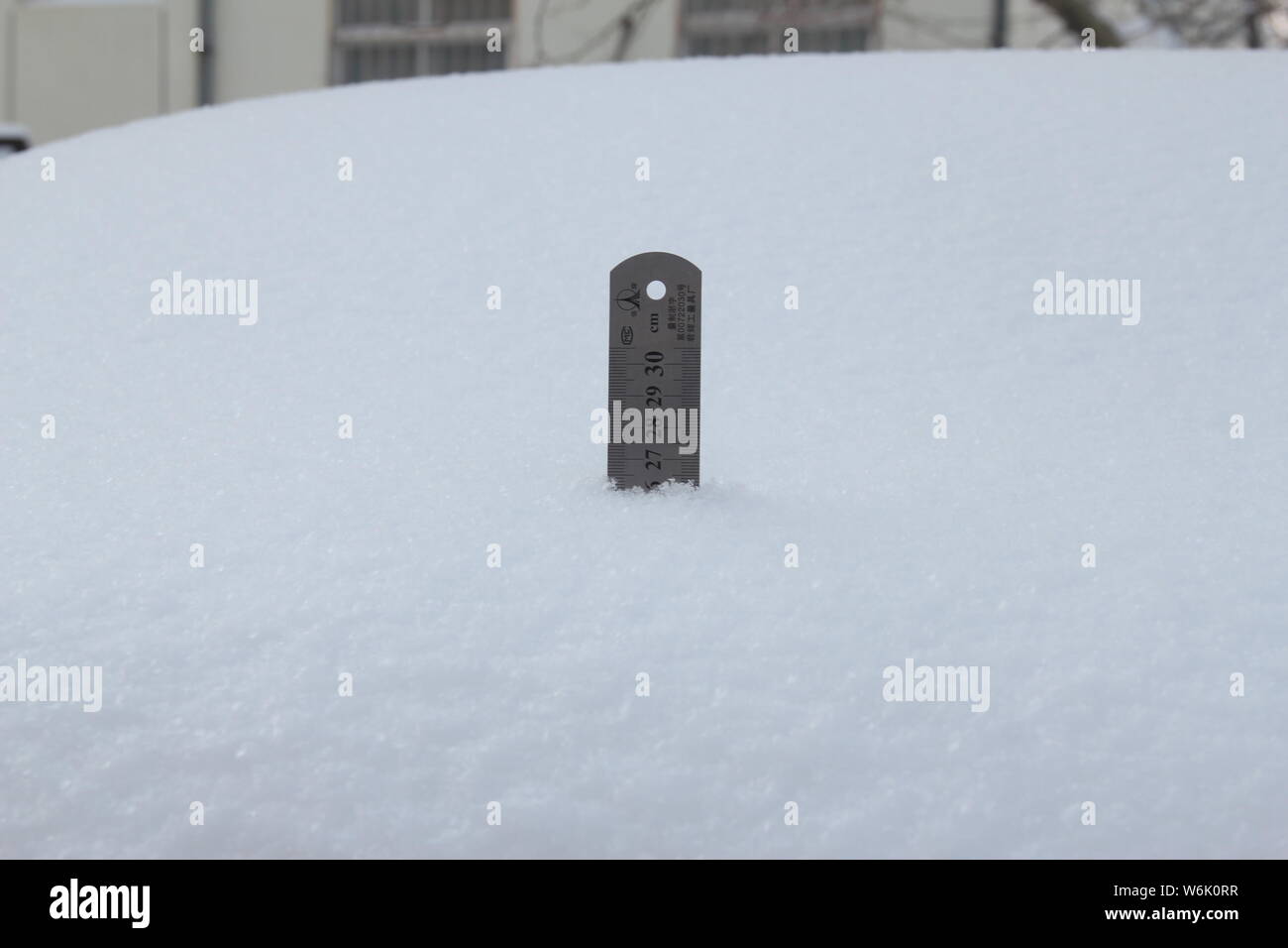 A ruler shows snow accumulating to over 30 centimeters during a ...