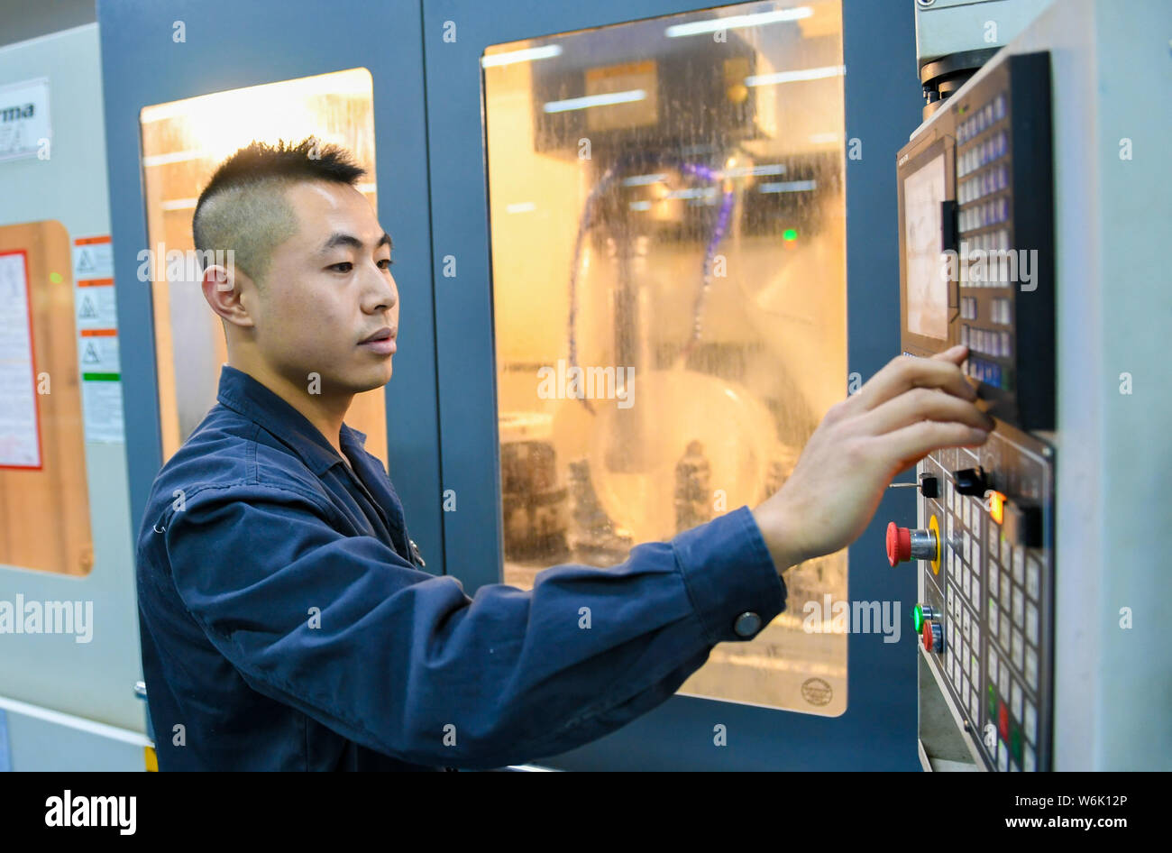 A Chinese worker processes crystal bars made of sapphire crystal at a ...