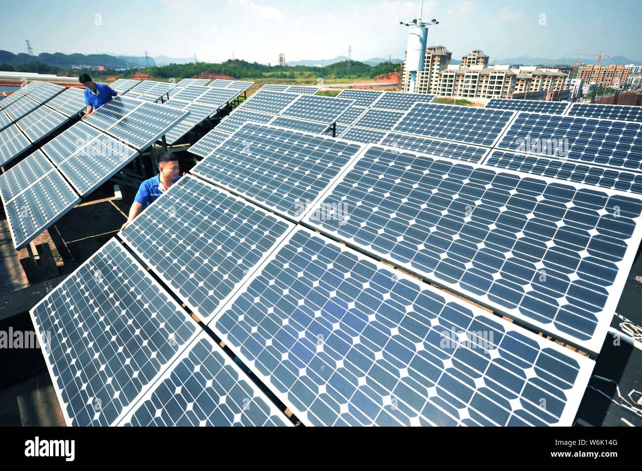 --FILE--Chinese workers install solar panels on the rooftop of a ...