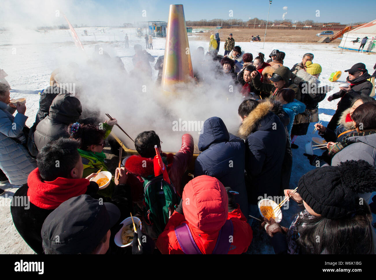 Tourists enjoy a giant hot pot during the first Ice and Snow Hotpot ...