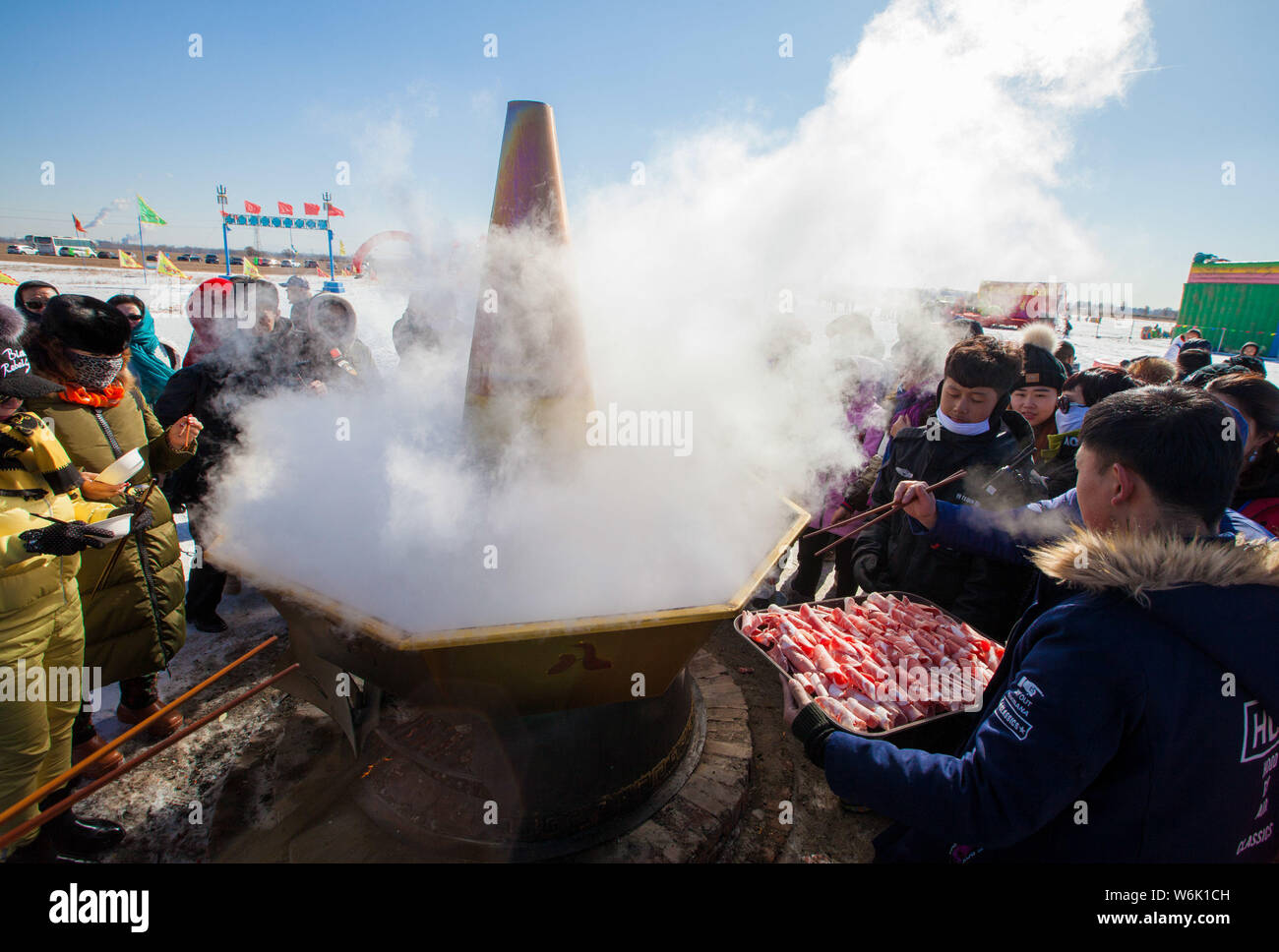 Tourists enjoy a giant hot pot during the first Ice and Snow Hotpot ...