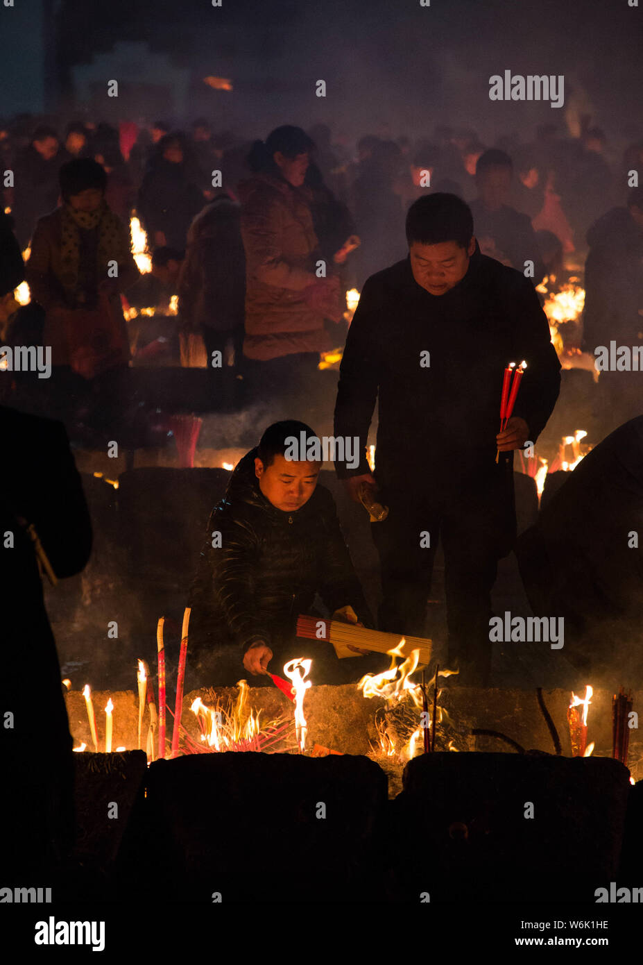 Chinese worshippers burn incense sticks to pray for wealth and ...