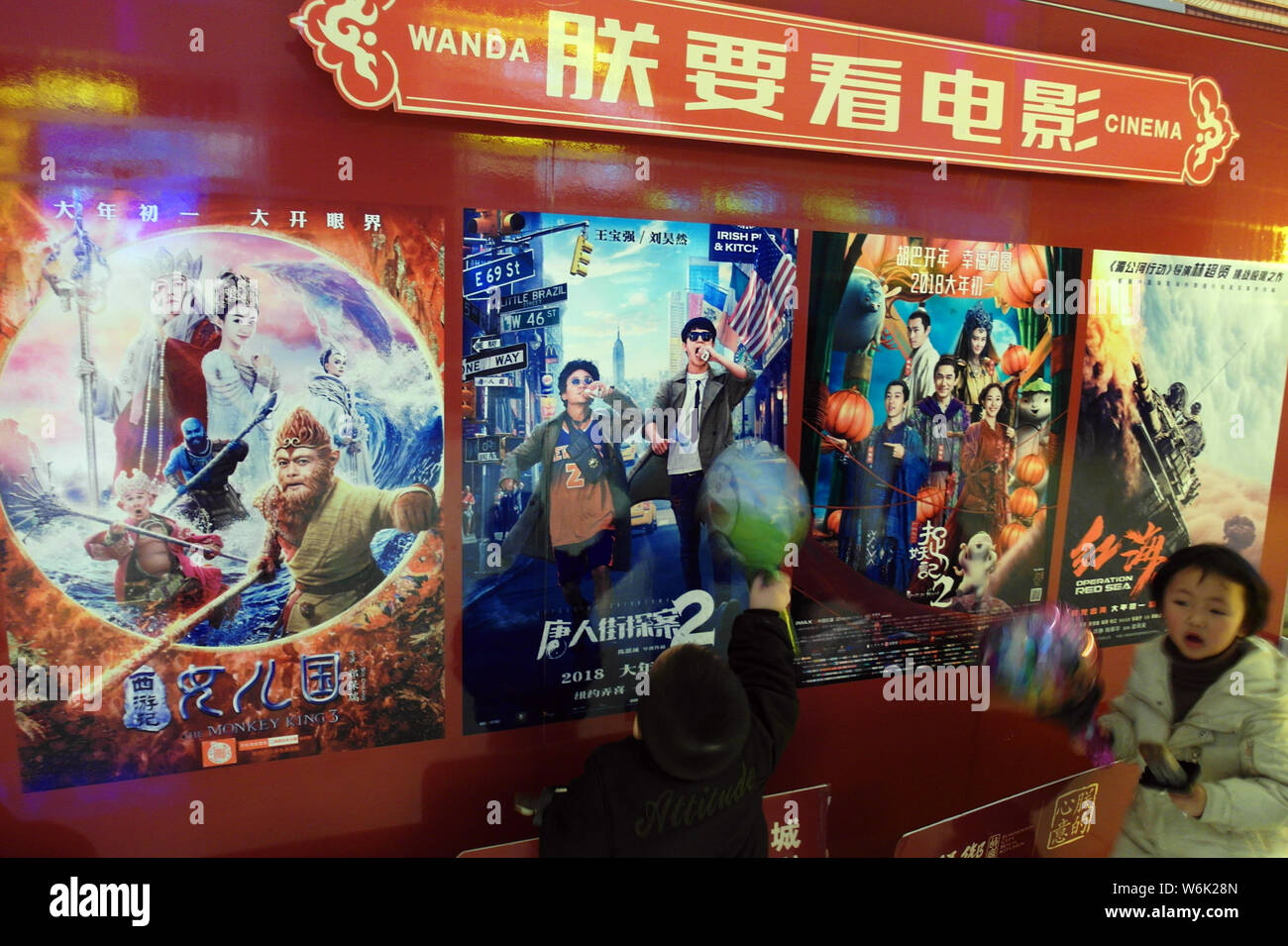 Children play in front of posters of movies on the first day of the ...