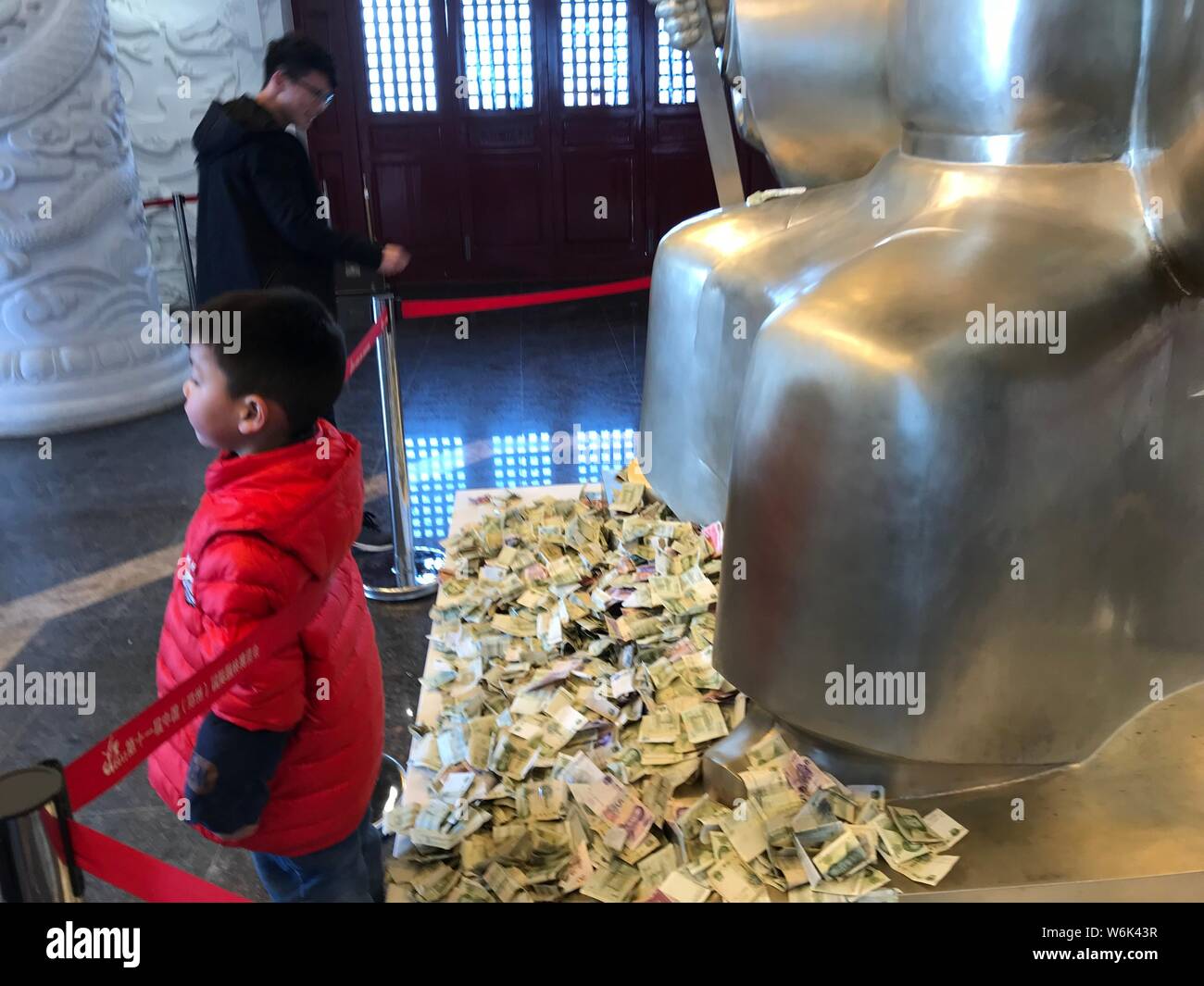A child poses photos with a statue of the Yellow Emperor, also known as ...