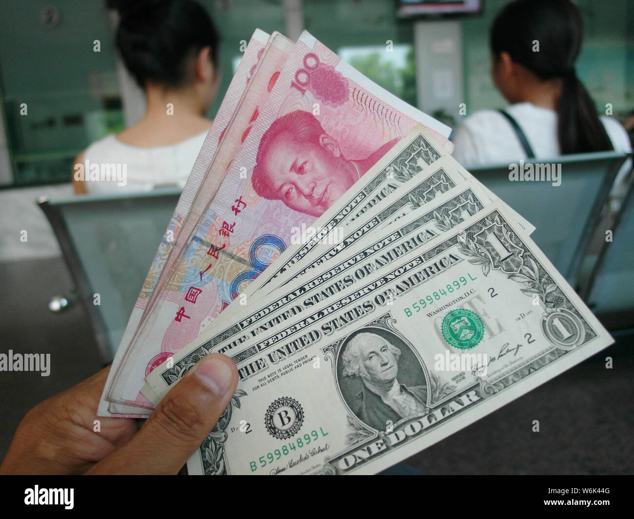 --FILE--A Chinese resident shows US dollar and RMB (renminbi) yuan ...